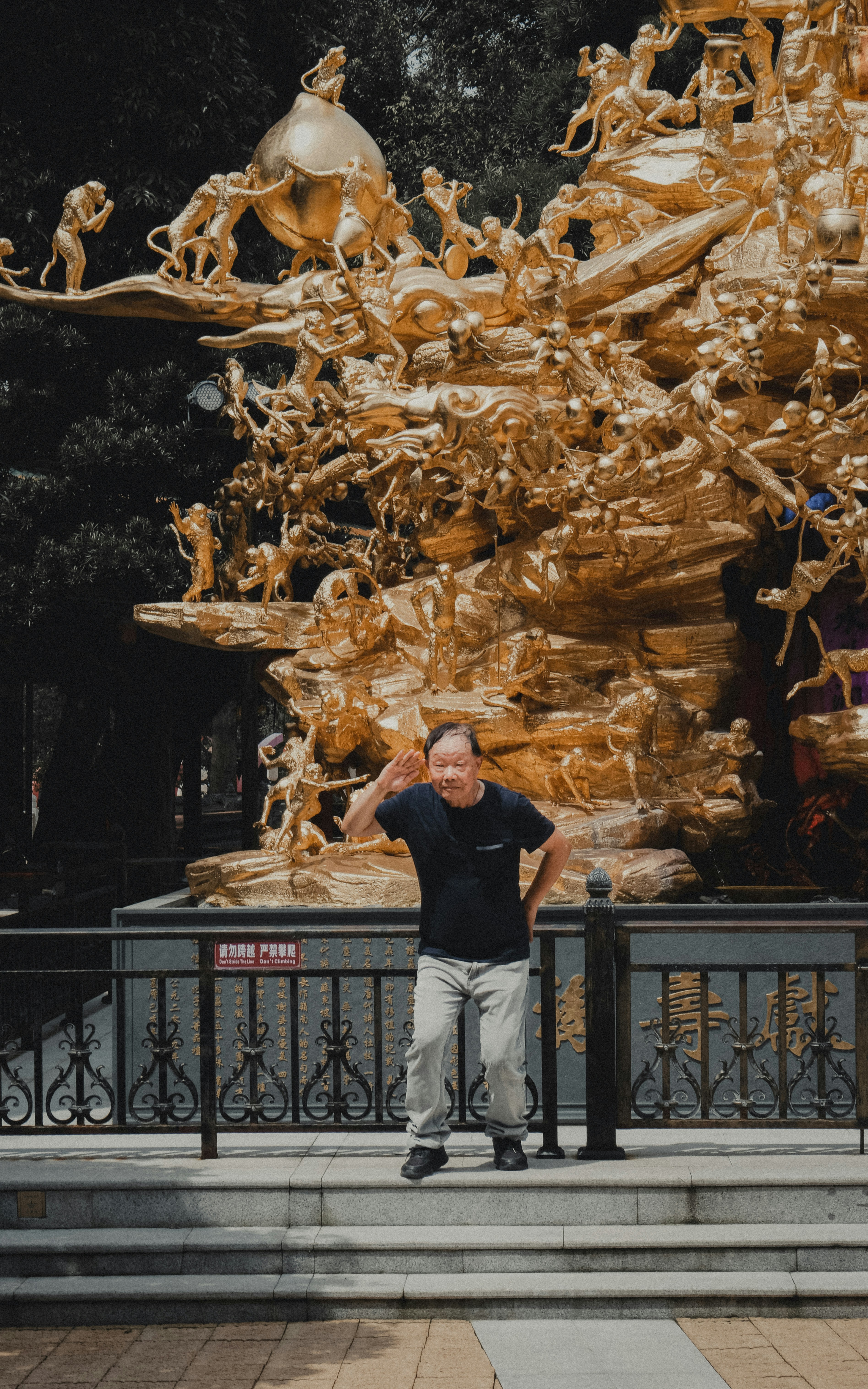 Dusty gold sculpture and man at its base