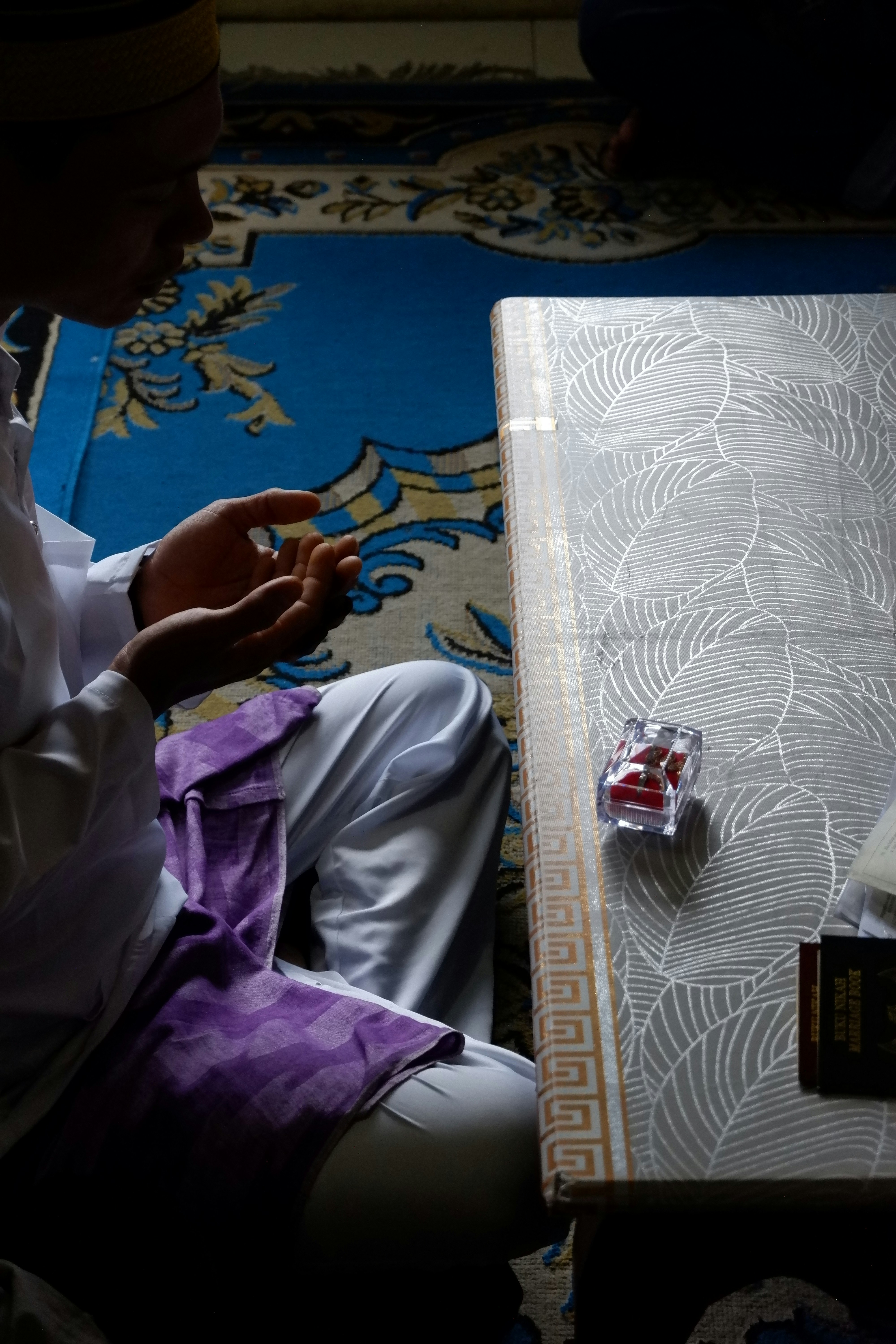 Close-up of a Silent Moment: A Child’s Hands Over a Patterned Table