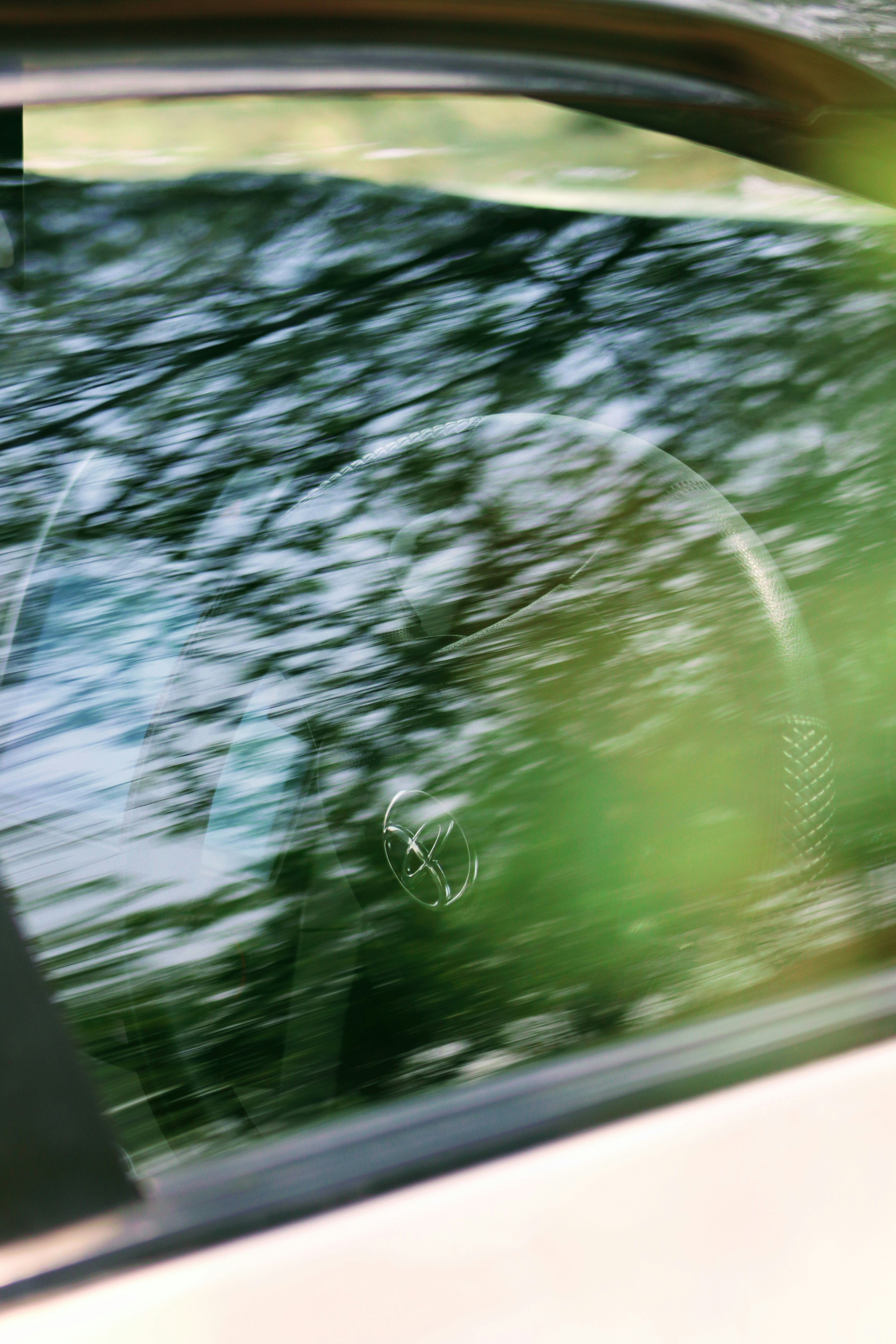 A blurry photo of a car's dashboard with trees in the background photo ...