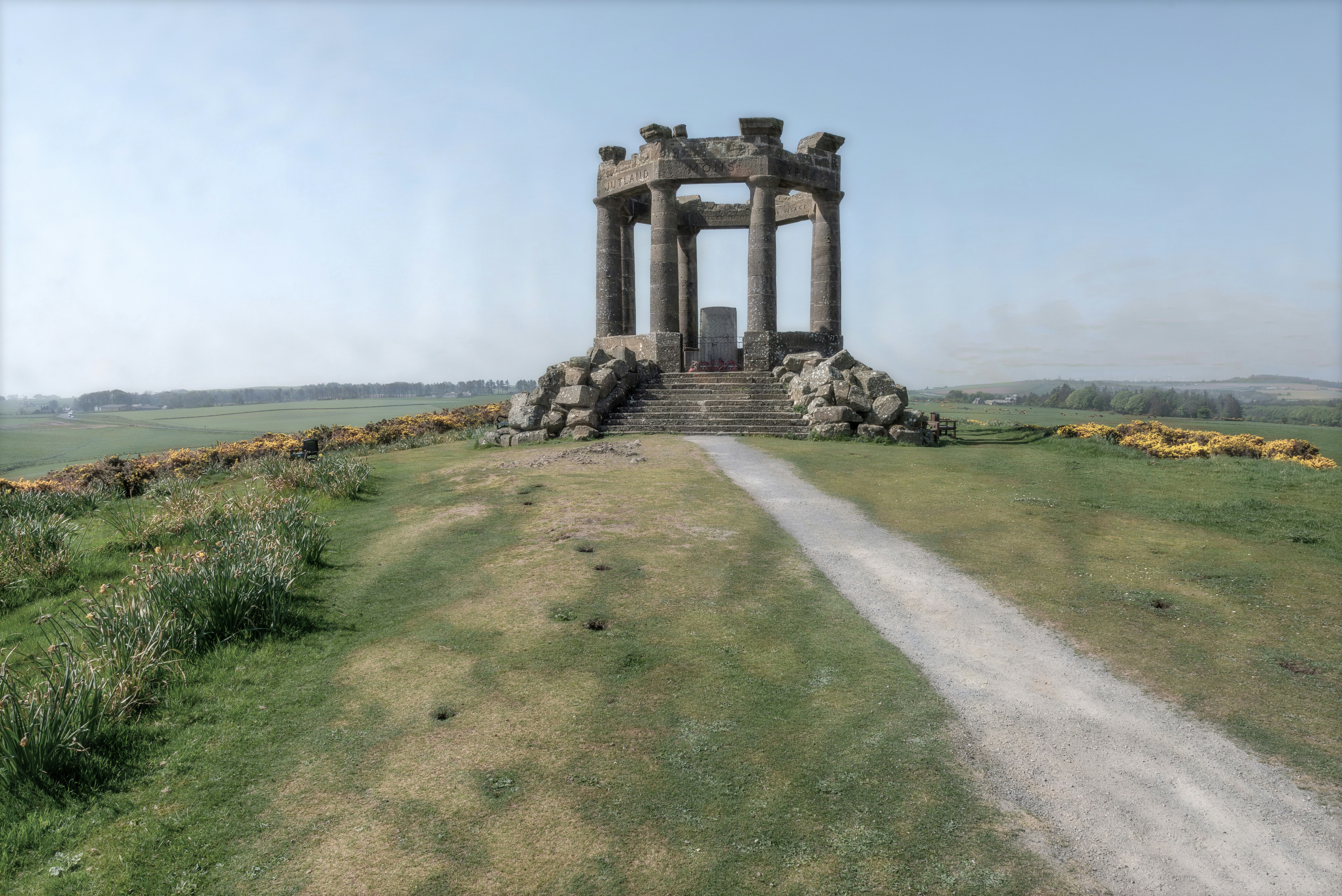 A large stone structure sitting on top of a lush green field photo ...