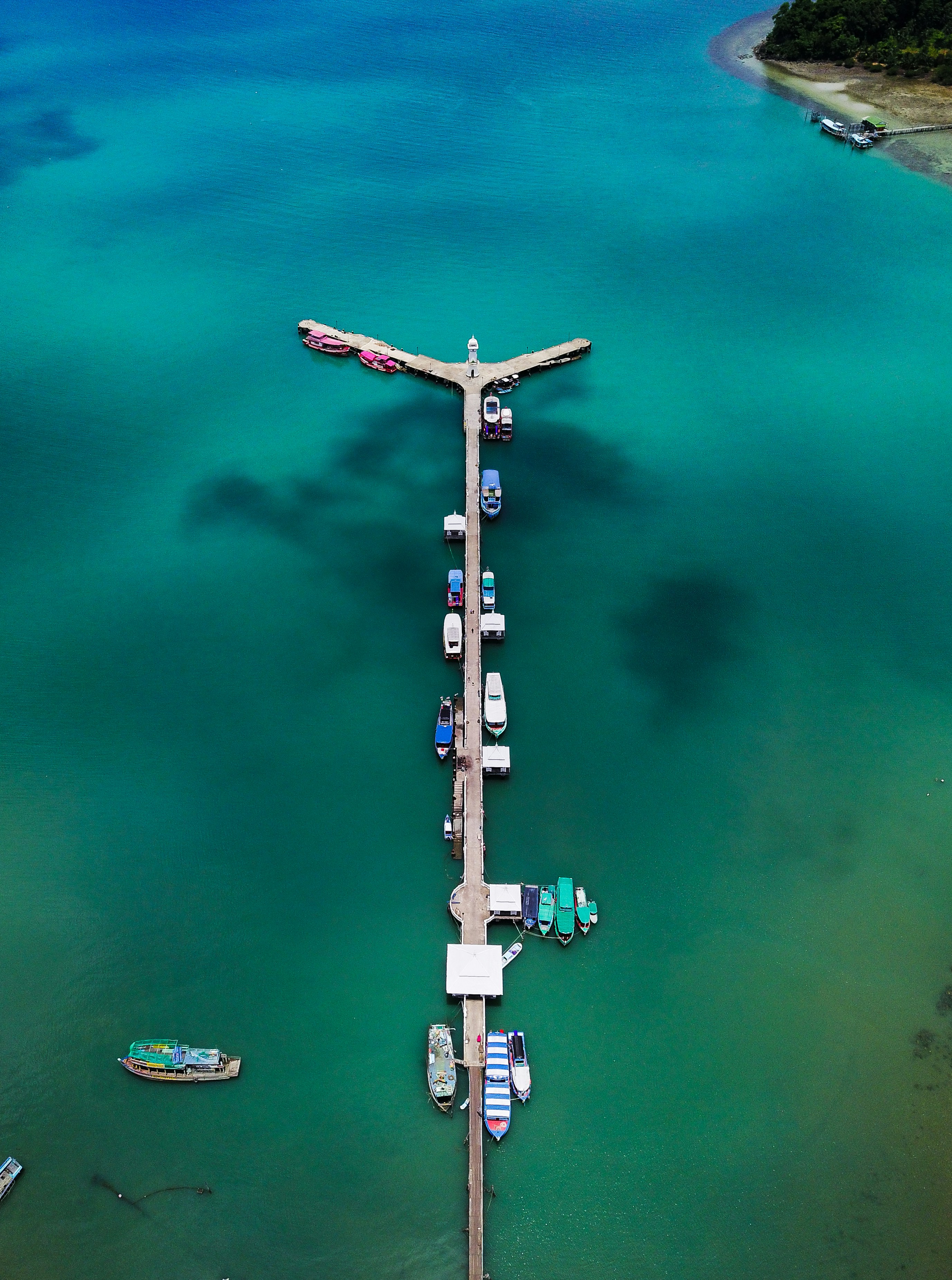 Turquoise Harbor Pier: A Drone's Eye on Boats and Lighthouse
