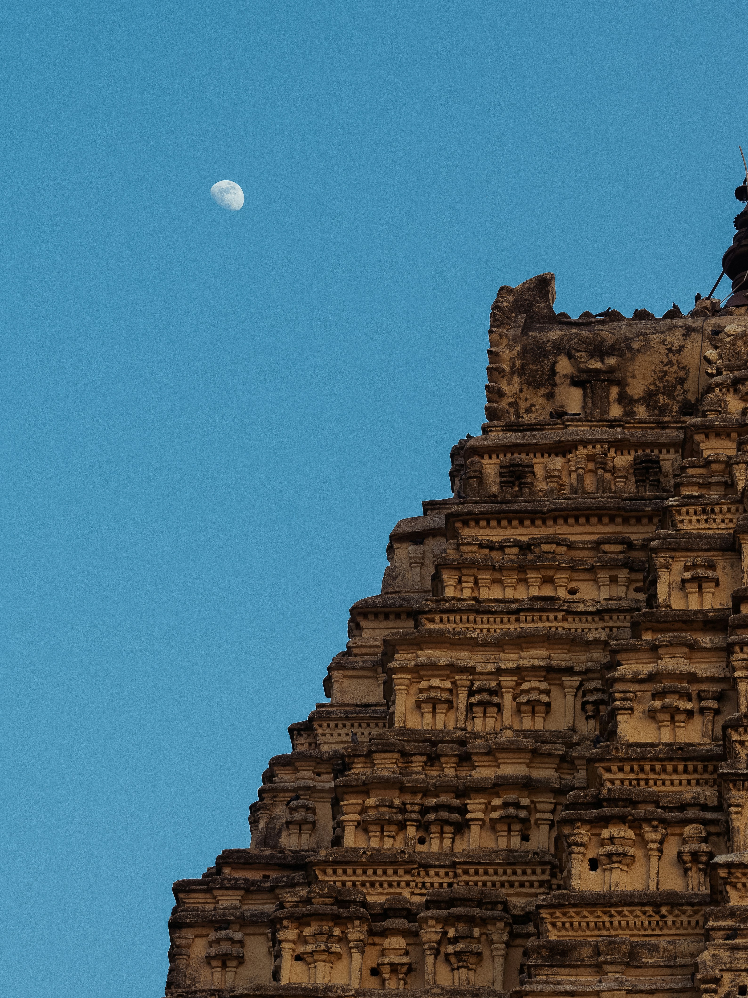 A very tall tower with a clock on it's side photo – Free Hampi Image on ...