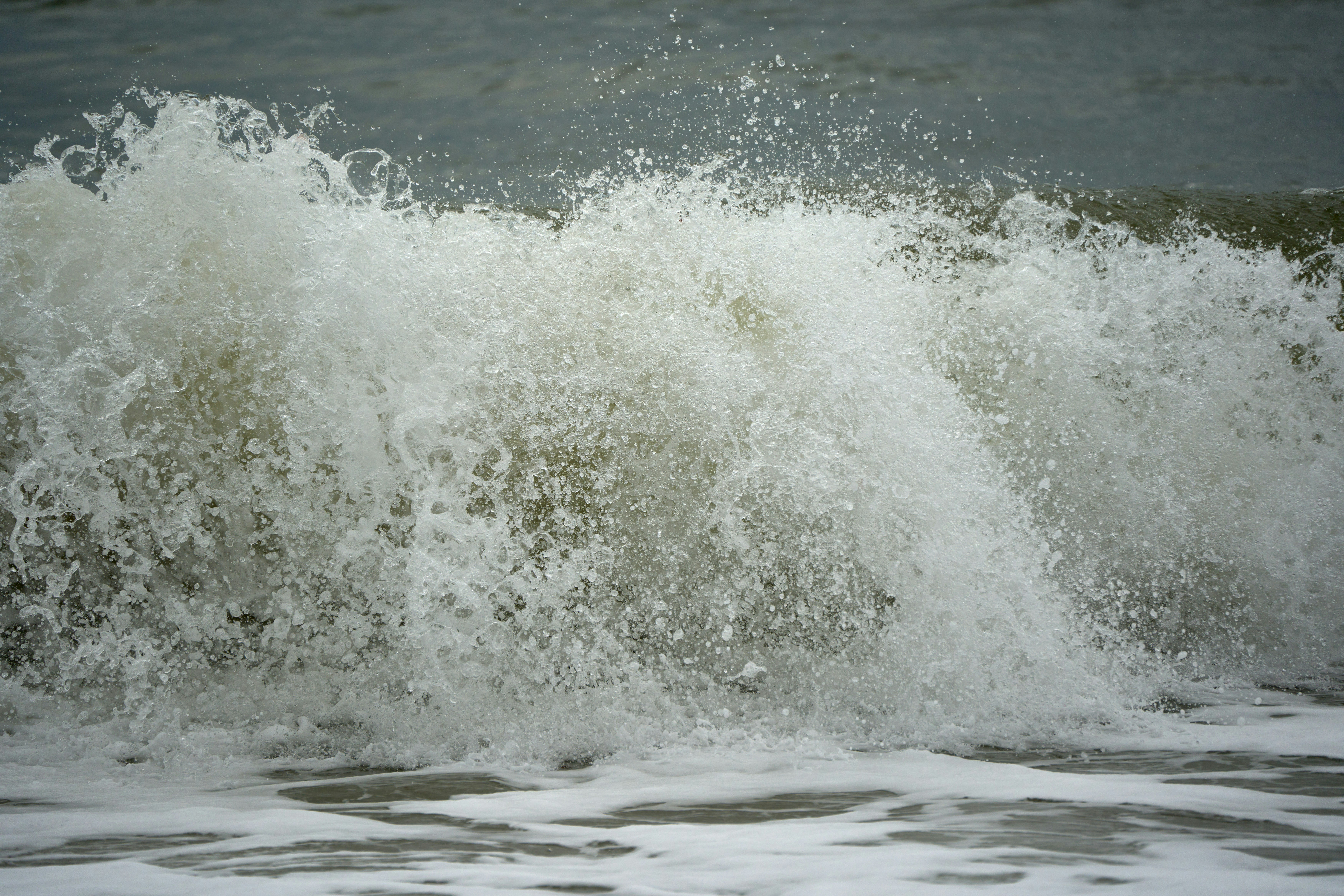 Cresting Wave Curtain: White Foam Unfurls Against the Shore