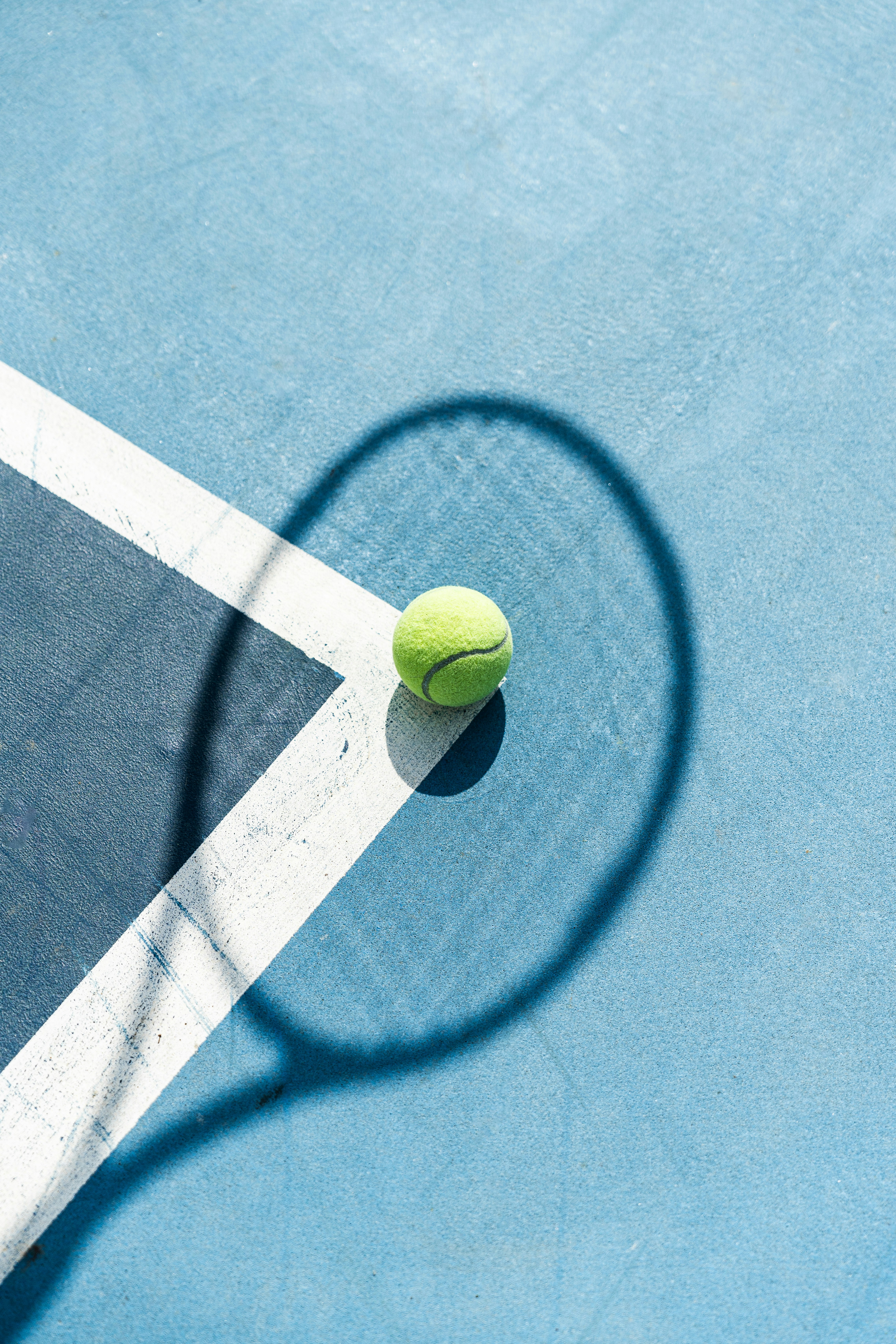 A tennis ball and racket on a tennis court photo – Free Tennis Image on ...