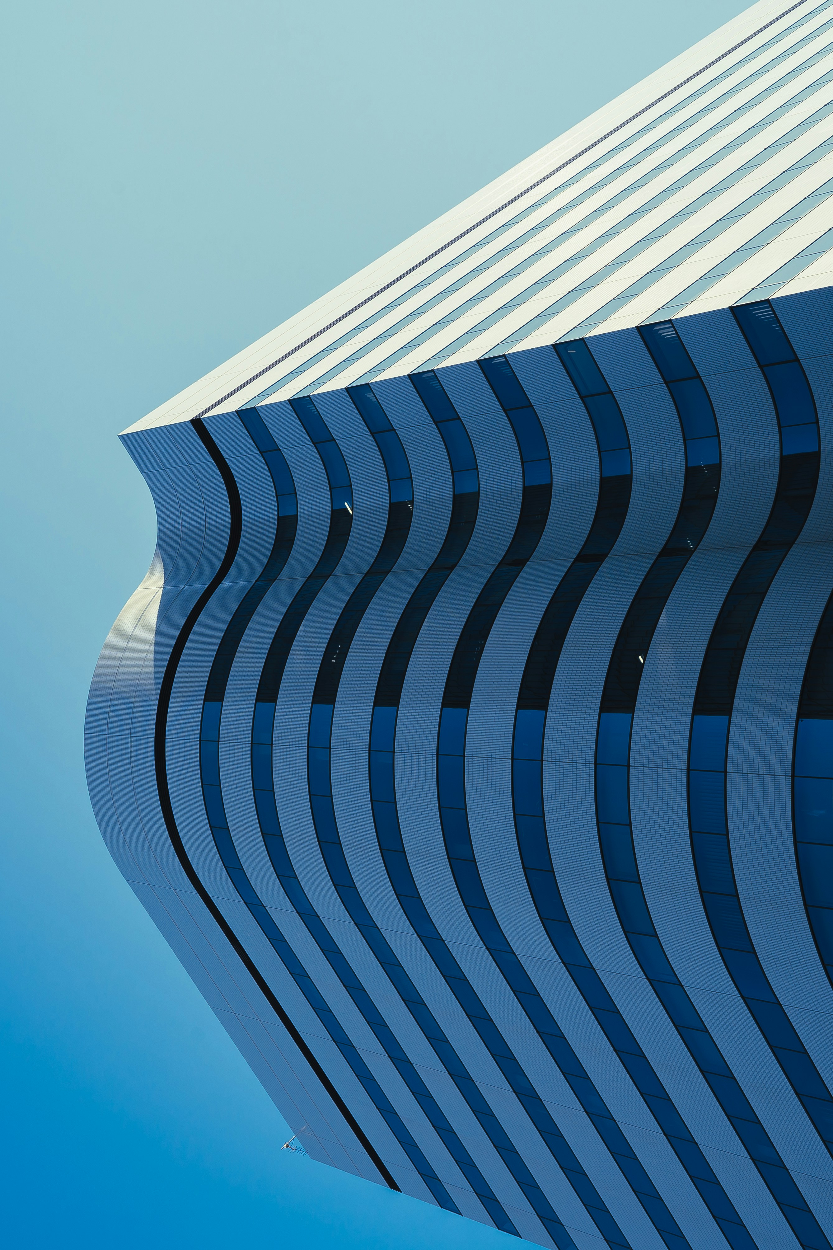 A blue and white striped building against a blue sky photo – Free ...