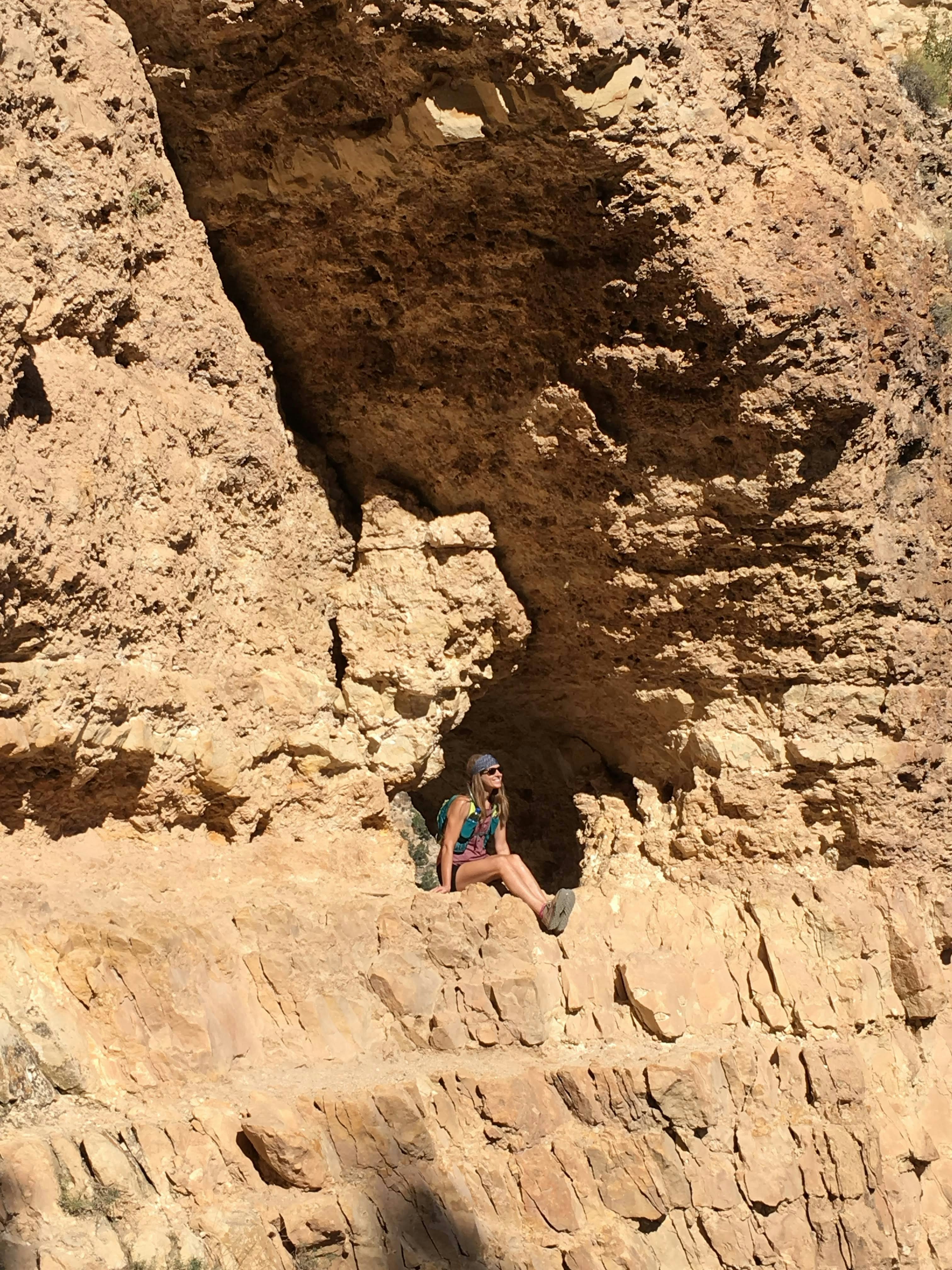 Solitary Pause on a Sun-Warmed Sandstone Ledge Beneath Towering Canyon Walls