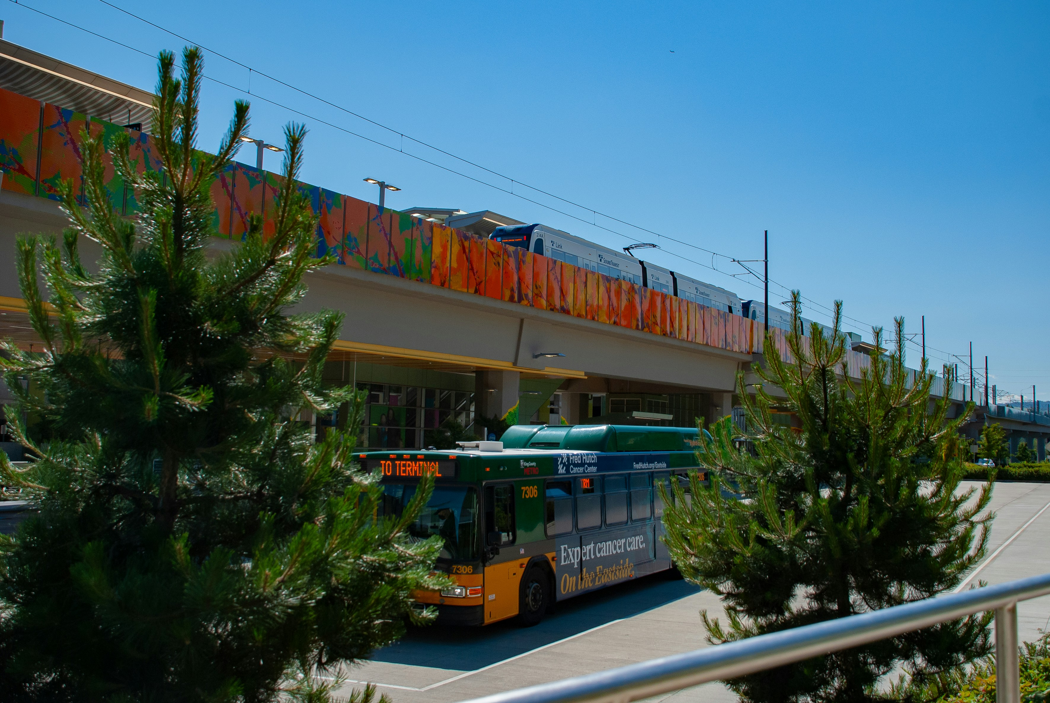 A bus driving down a street next to a bridge photo – Free Bellevue way ...