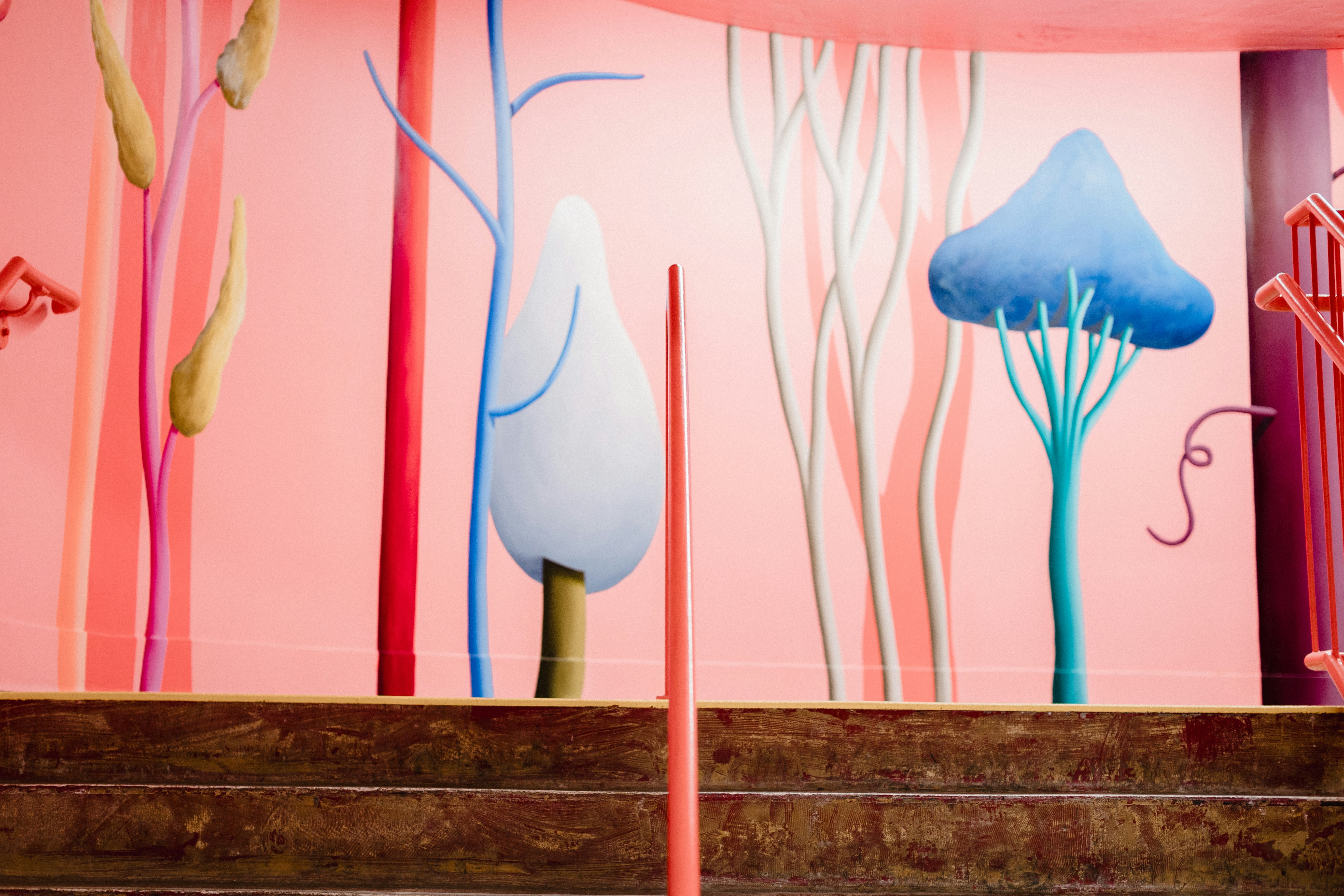 Pink Gallery Horizon: Playful Abstract Plant Forms on a Painted Wall
