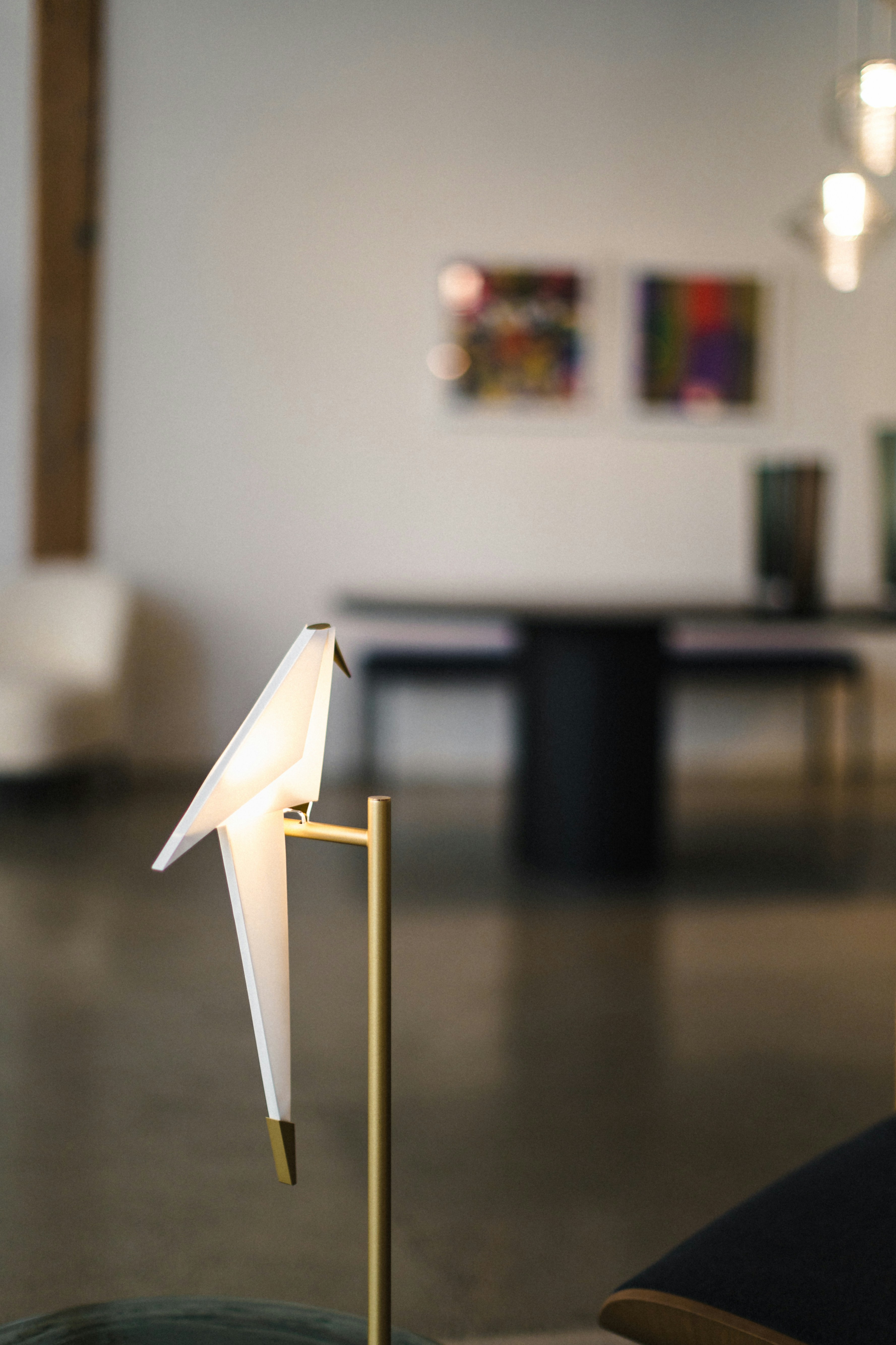 White Origami Sculpture on Brass Stand Anchors a Quiet Gallery Scene