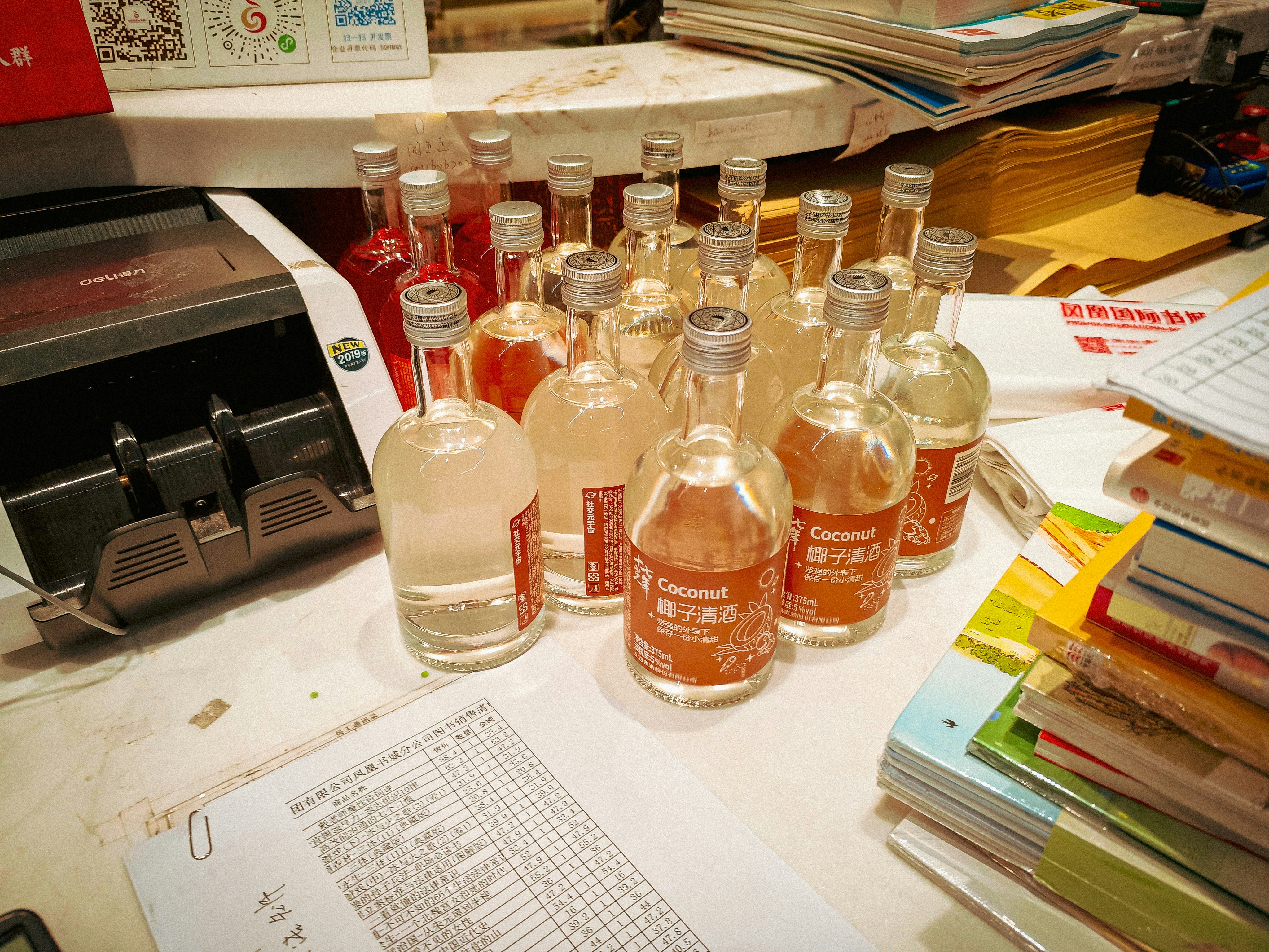 Glass Bottles in a Busy Desk: Focus on Coconut Syrups Amid Office Clutter
