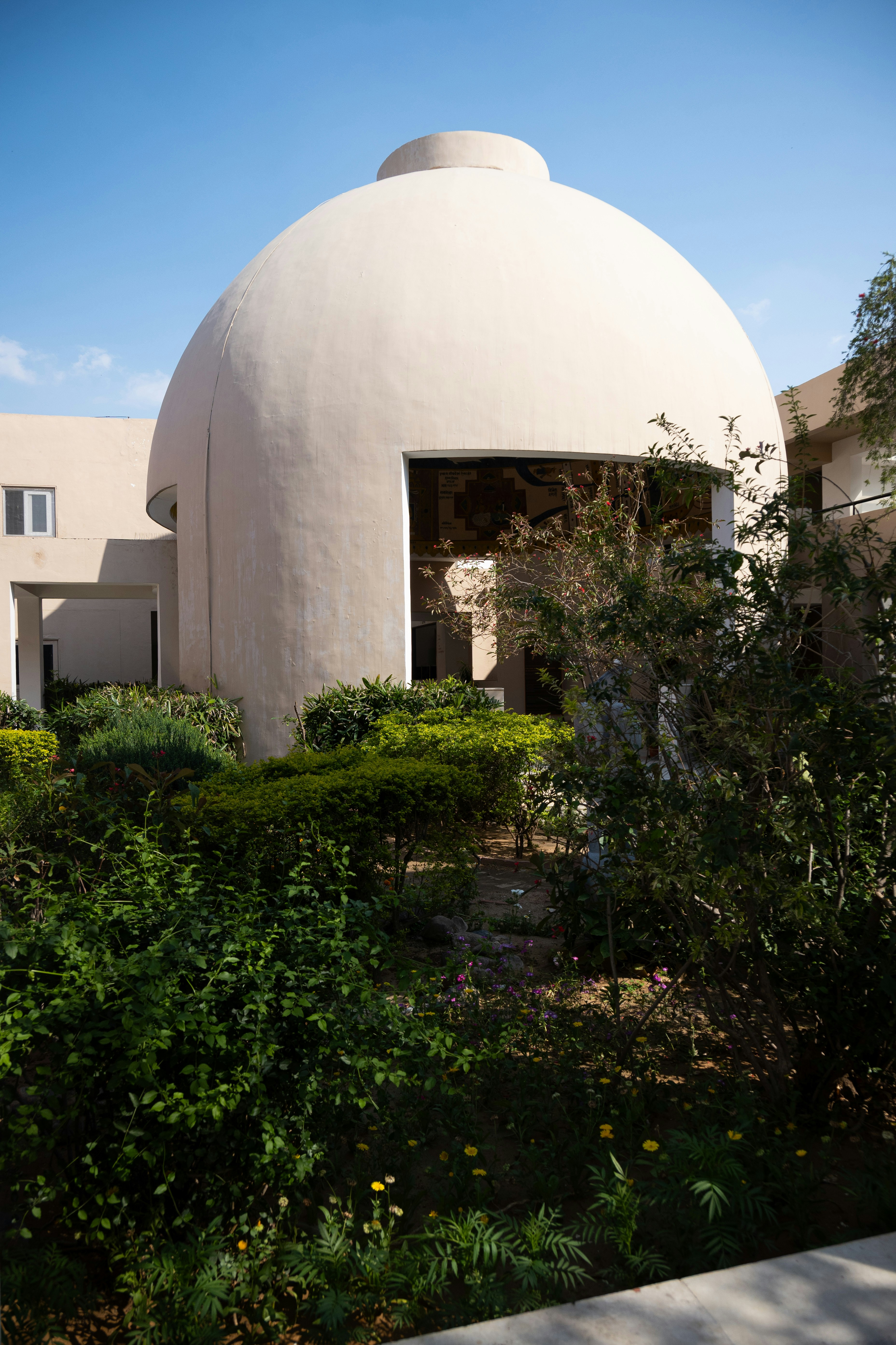 The Quiet Dome: A Stucco Sphere Framed by Desert Garden