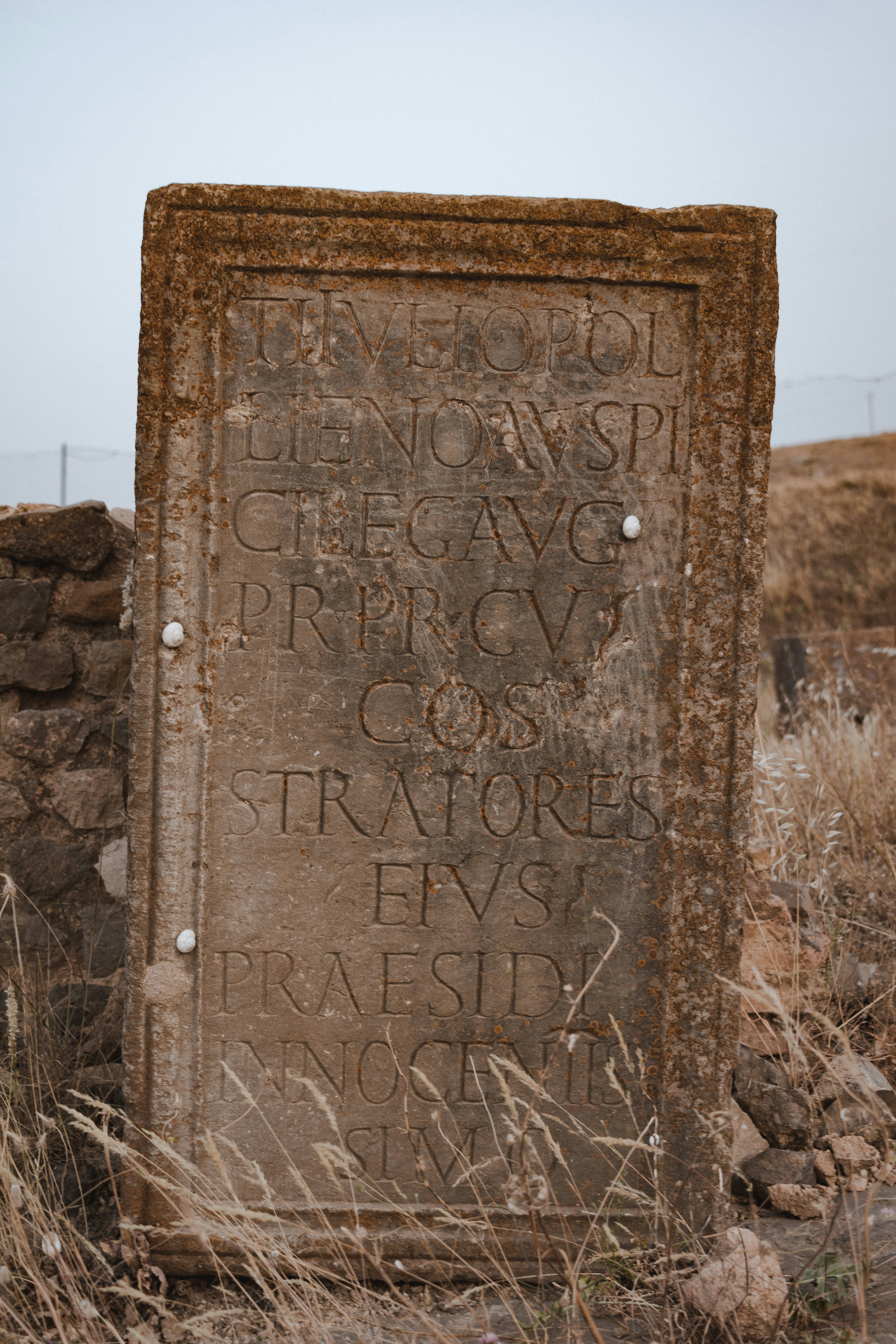 A stone monument with writing on it in a field photo – Free Green Image ...