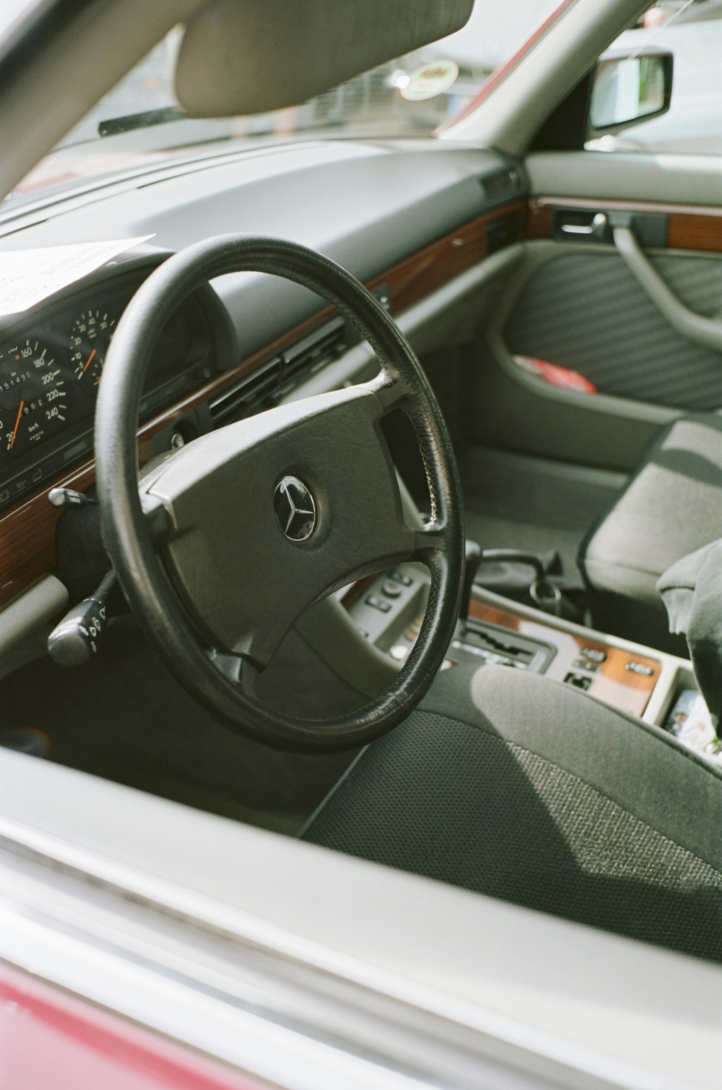 Vintage Mercedes-Benz interior showcasing wood accents and a classic steering wheel.