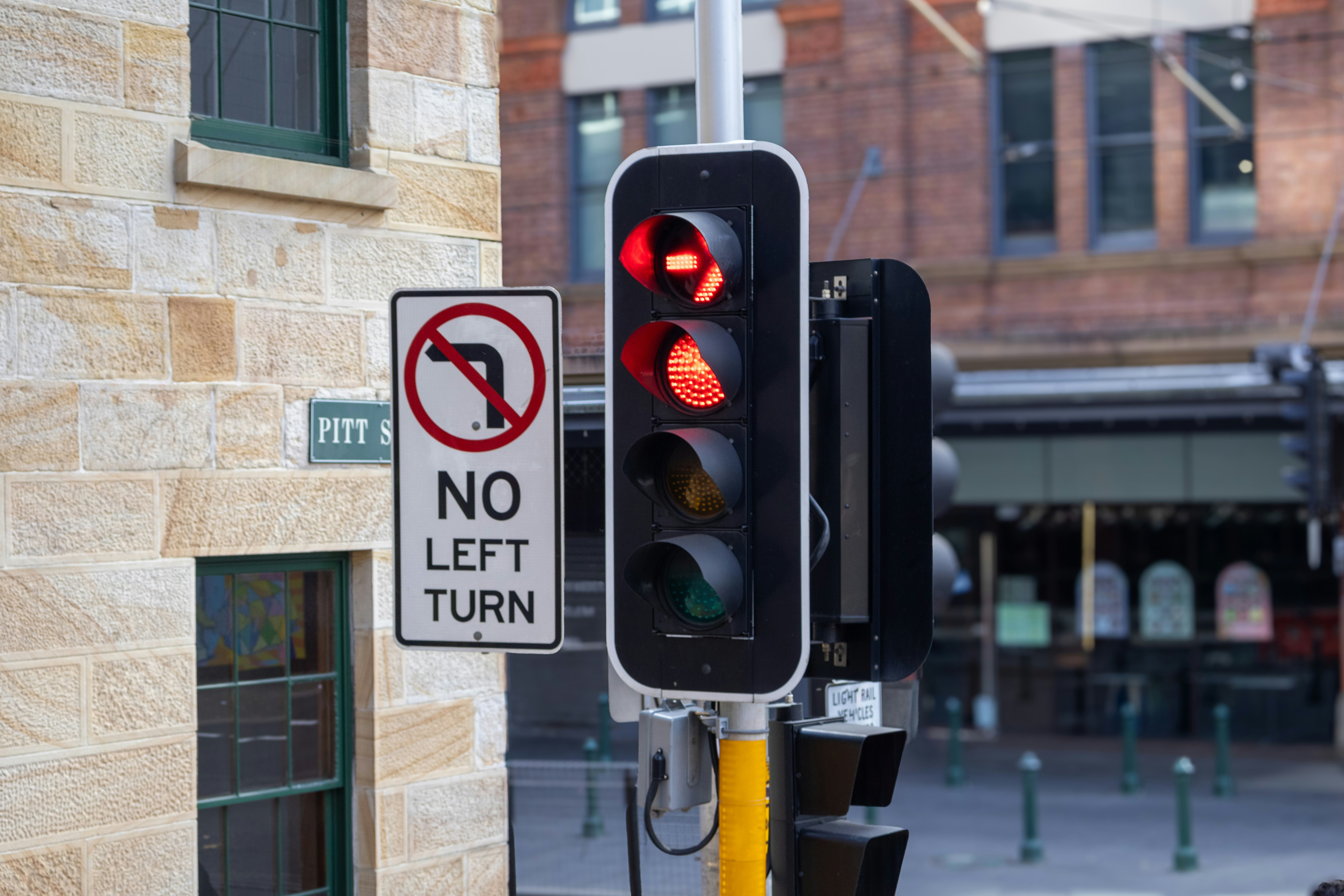 Red Signal at the No-Left-Turn Corner: Urban Brick and Signage Portrait
