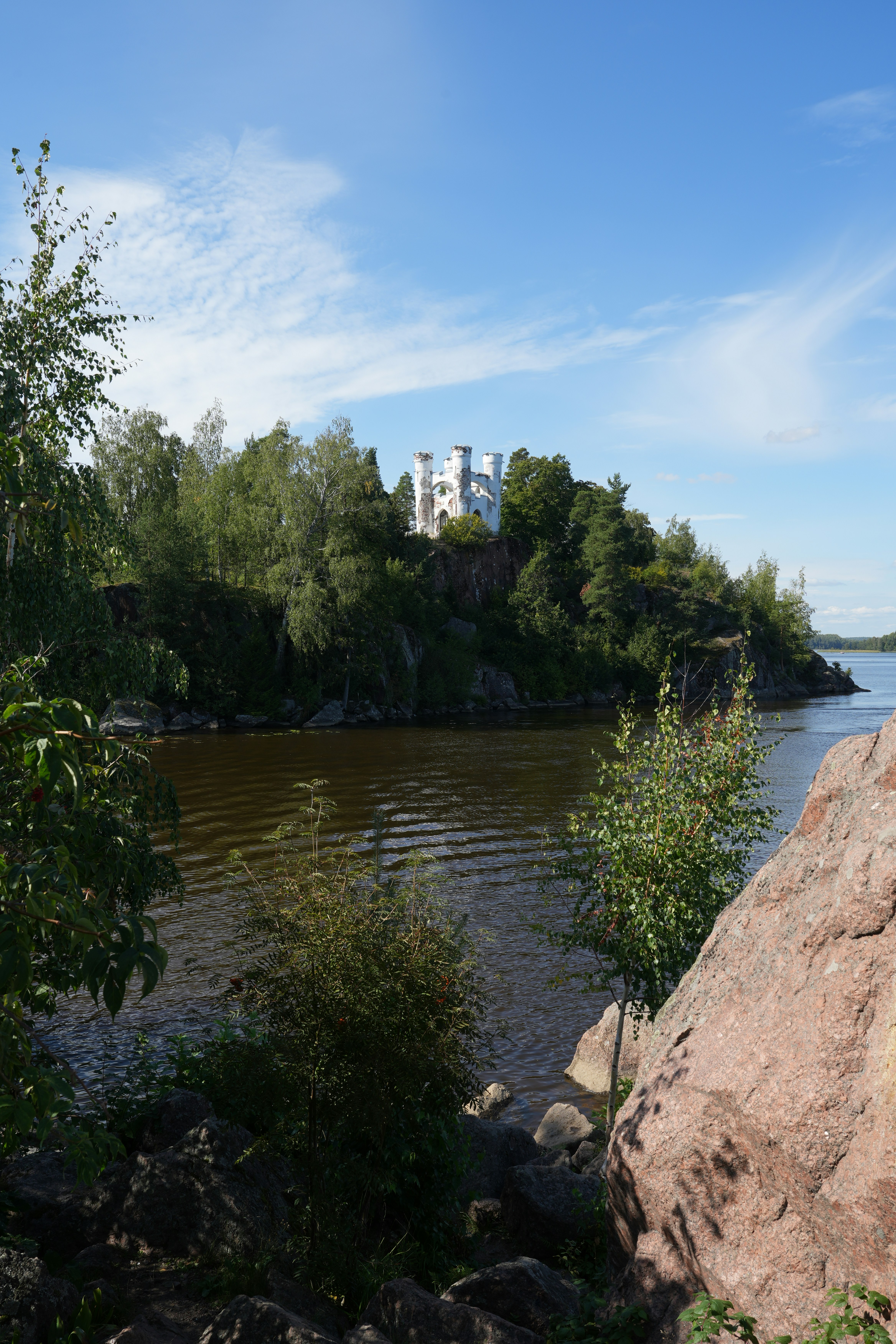 Ruin on the Riverbank: A Castle Silhouette Above Calm Waters