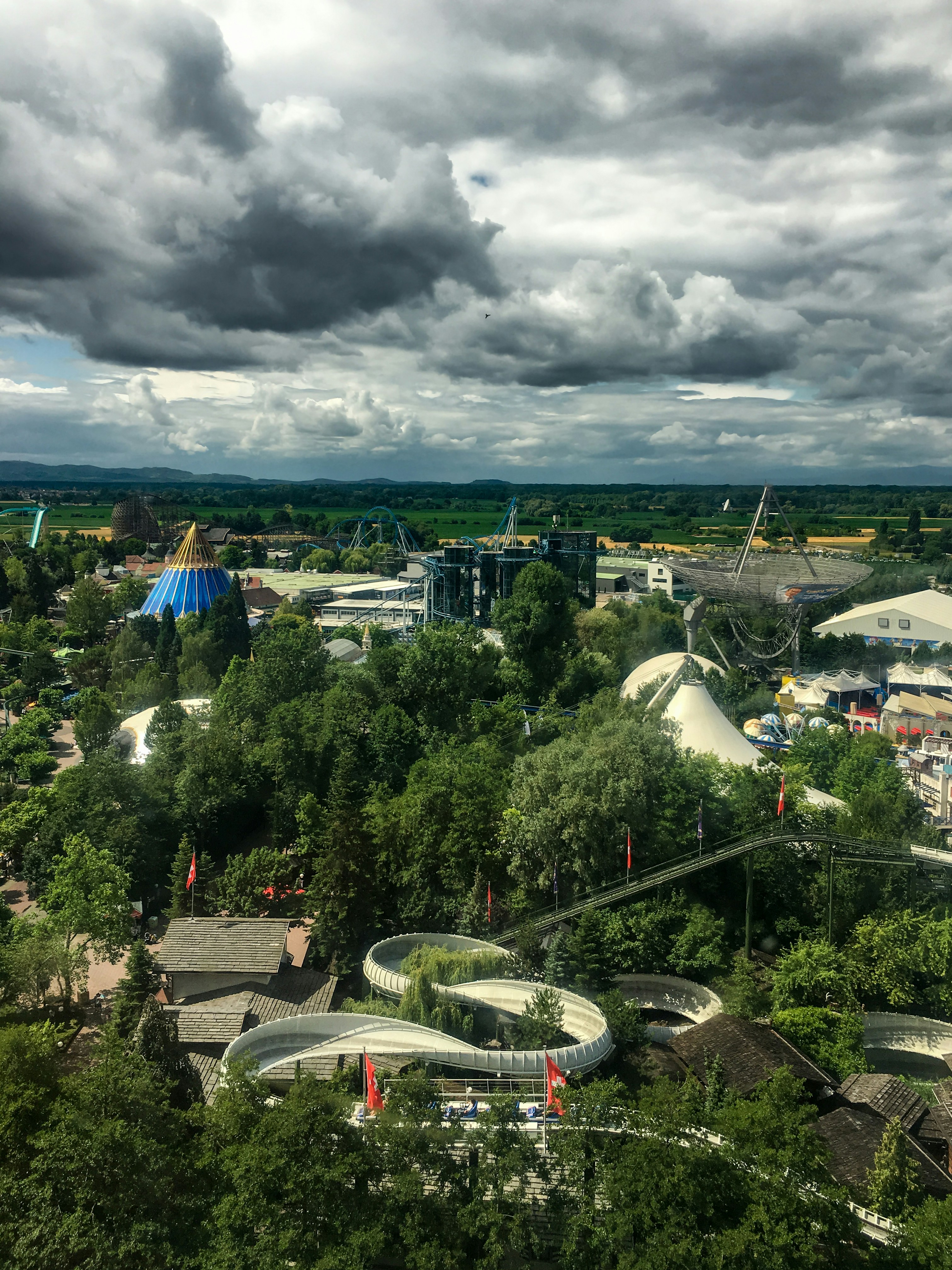Blue-Topped Cone and Verdant Trails: A Panoramic Theme-Park Vista