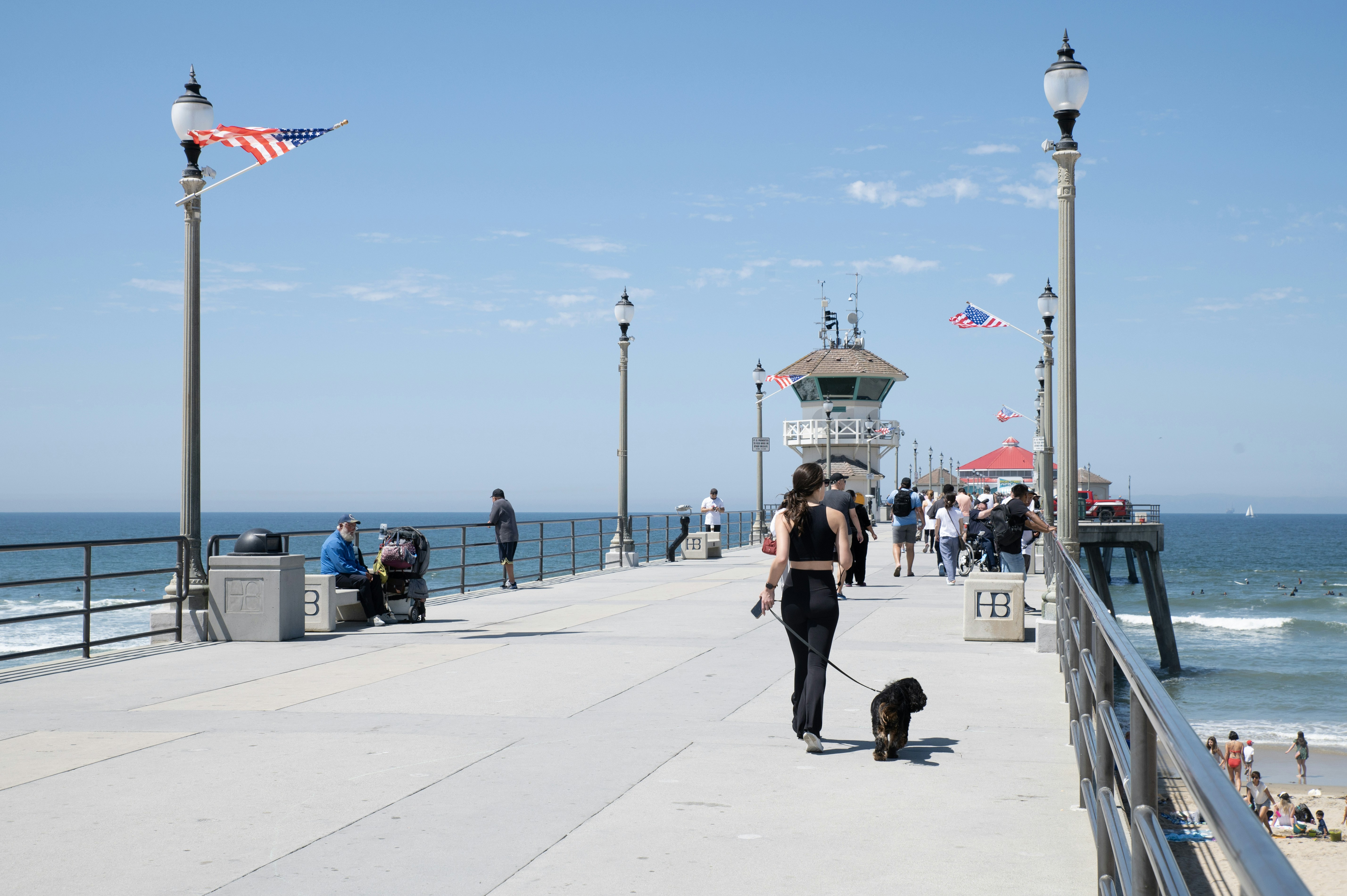 Flag-Washed Pier: A Midday Stroll Toward the Lifeguard Tower