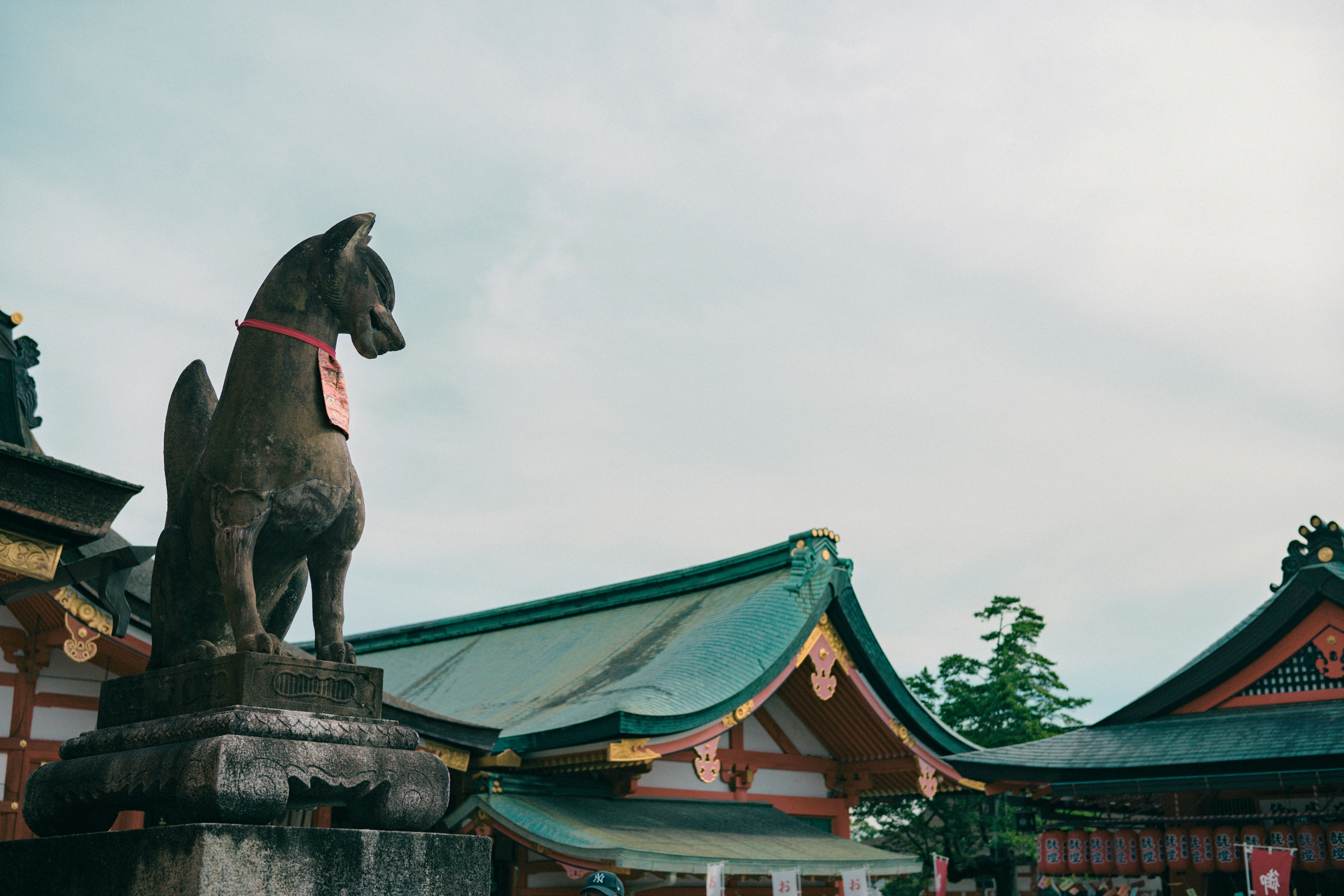Stone Guardian: A Japanese Shrine Horse Amid Calm Temple Roofs