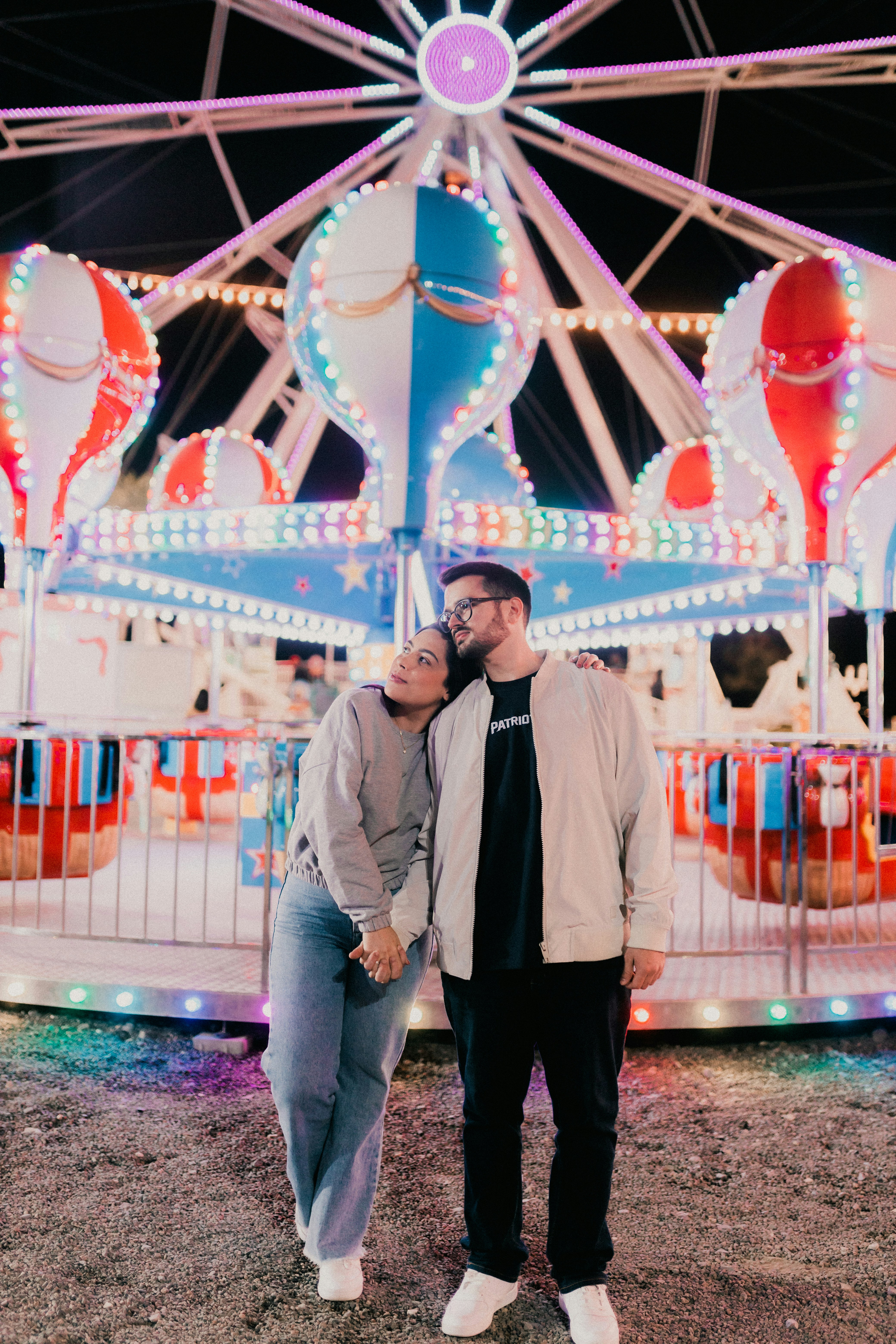 A man and a woman standing in front of a carnival ride photo – Free ...