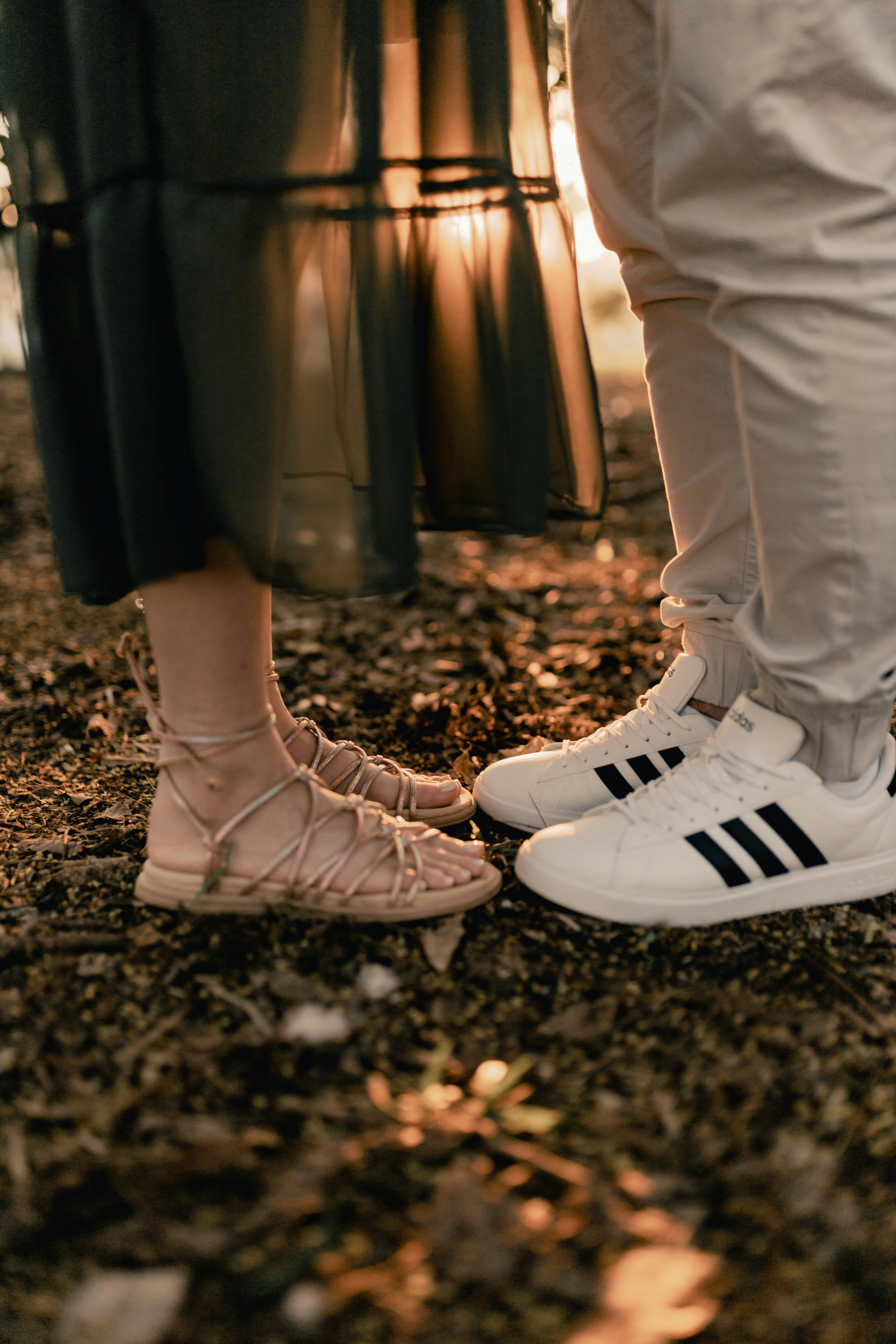 Sunset Footing: Sandals and Sneakers Meet at Ground Level