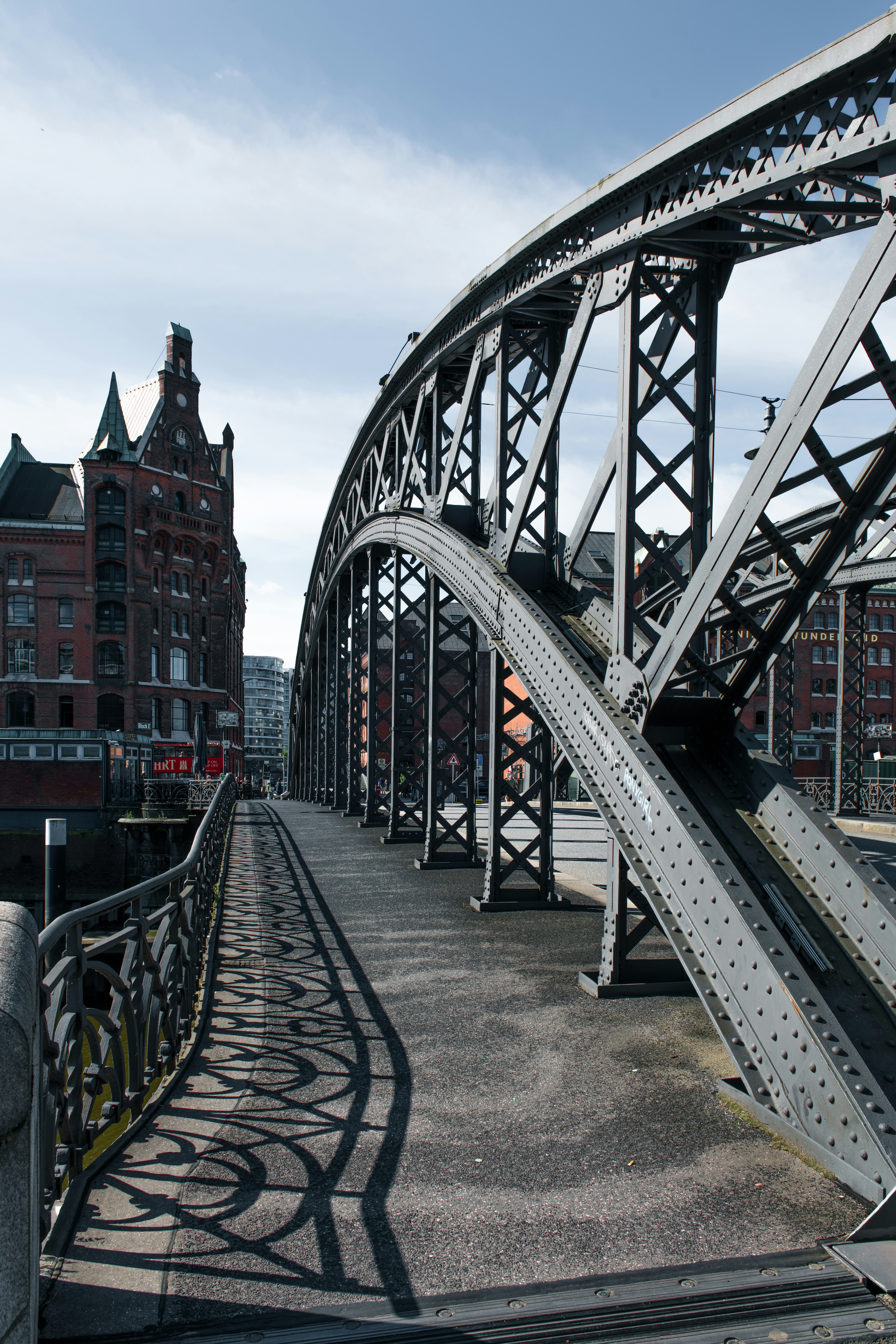 A large metal bridge over a river next to tall buildings photo – Free ...