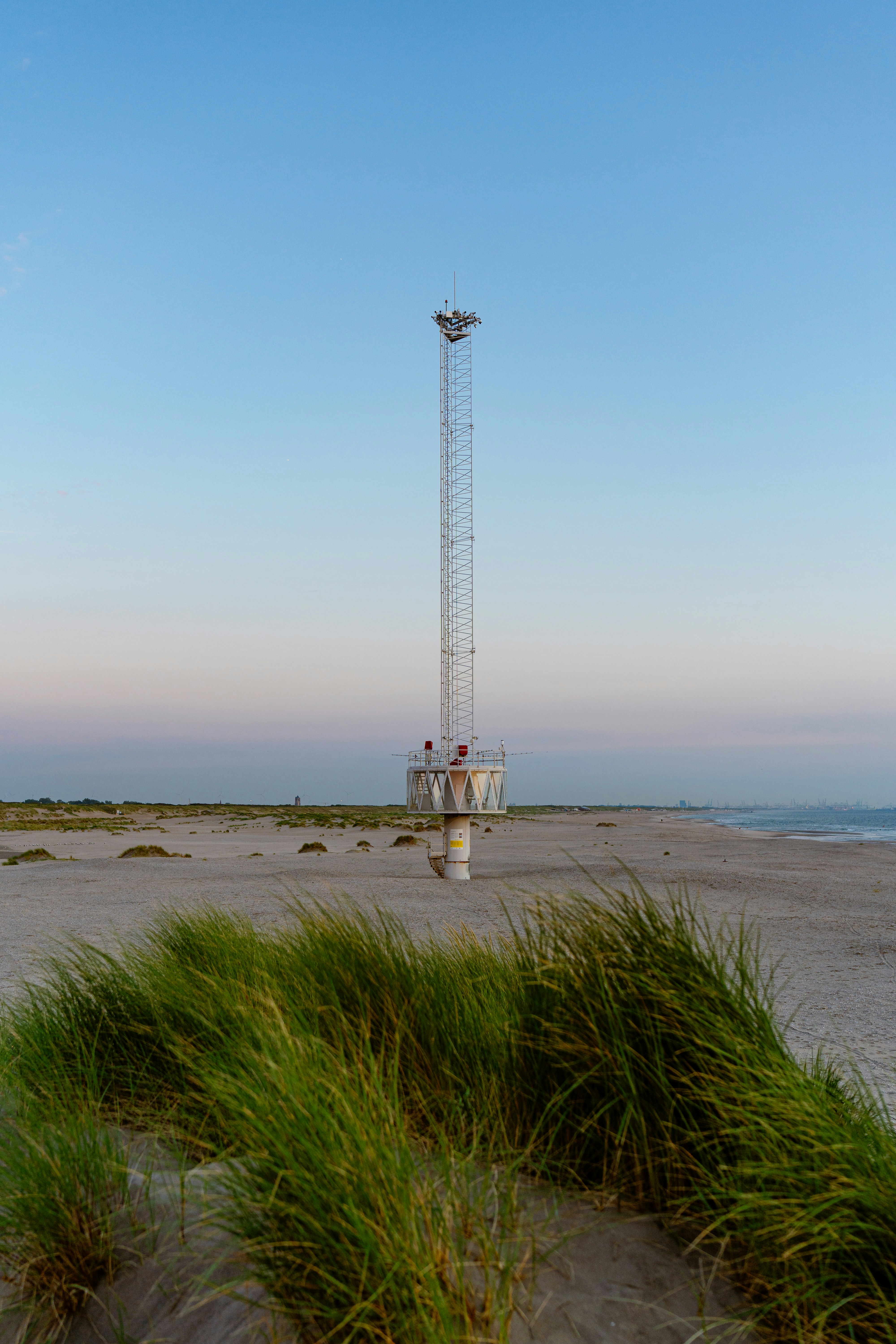 Dune-Edge Lattice Tower at Dusk: A Quiet Beacon by the Sea