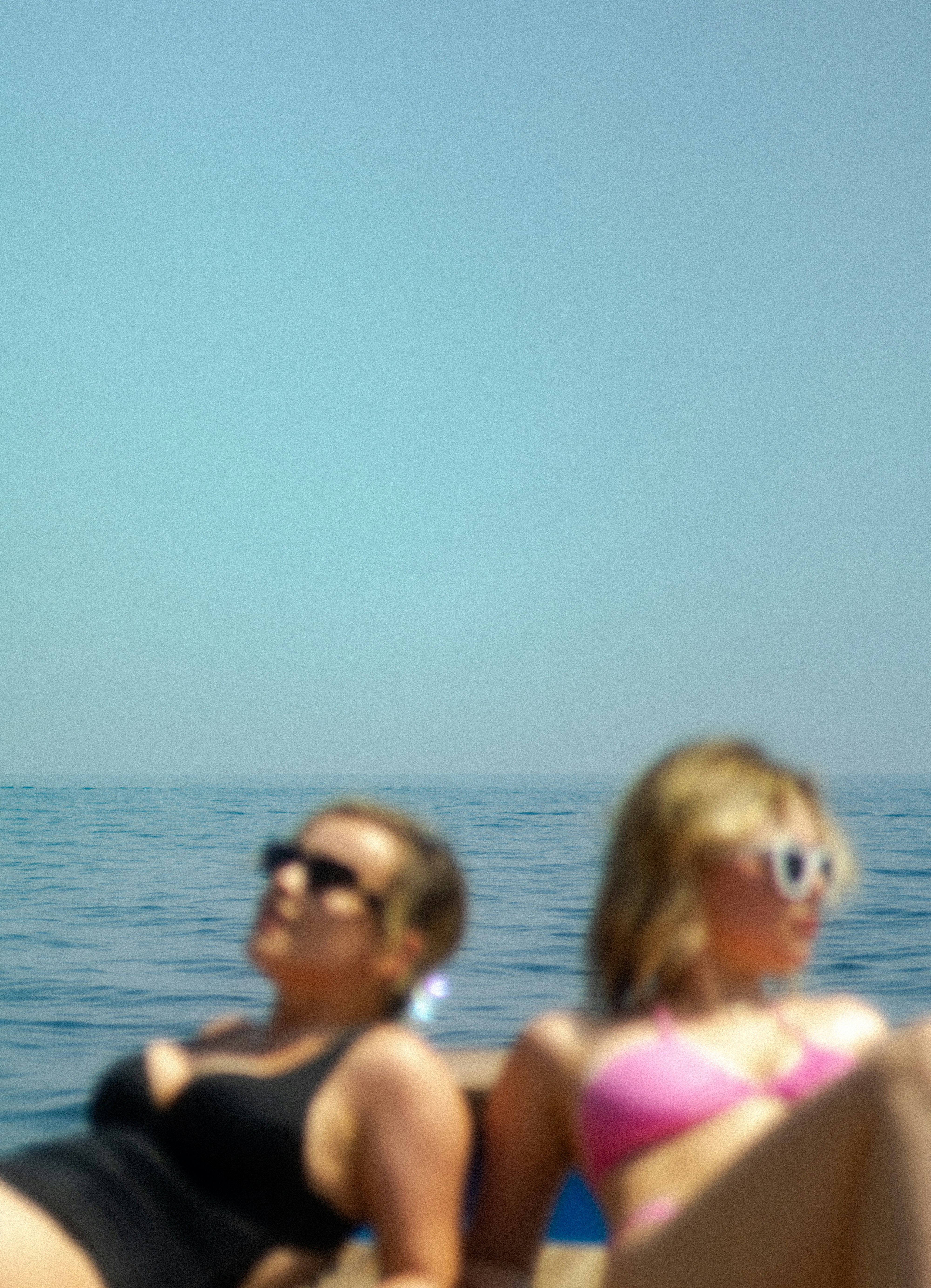 Blurred by the Breeze: Sunbathers Repose by a Quiet Seascape