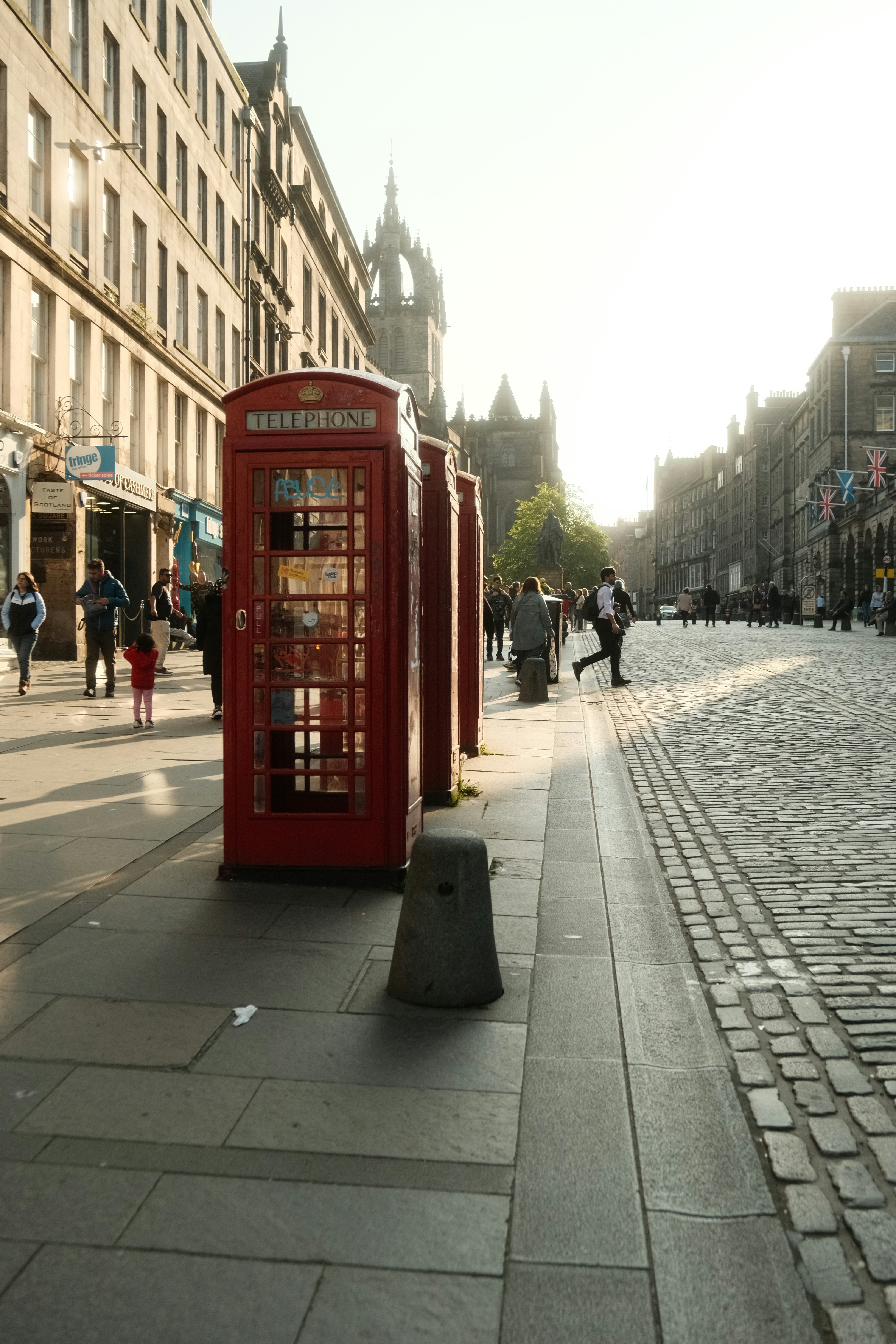 A red phone booth sitting on the side of a street photo – Free ...