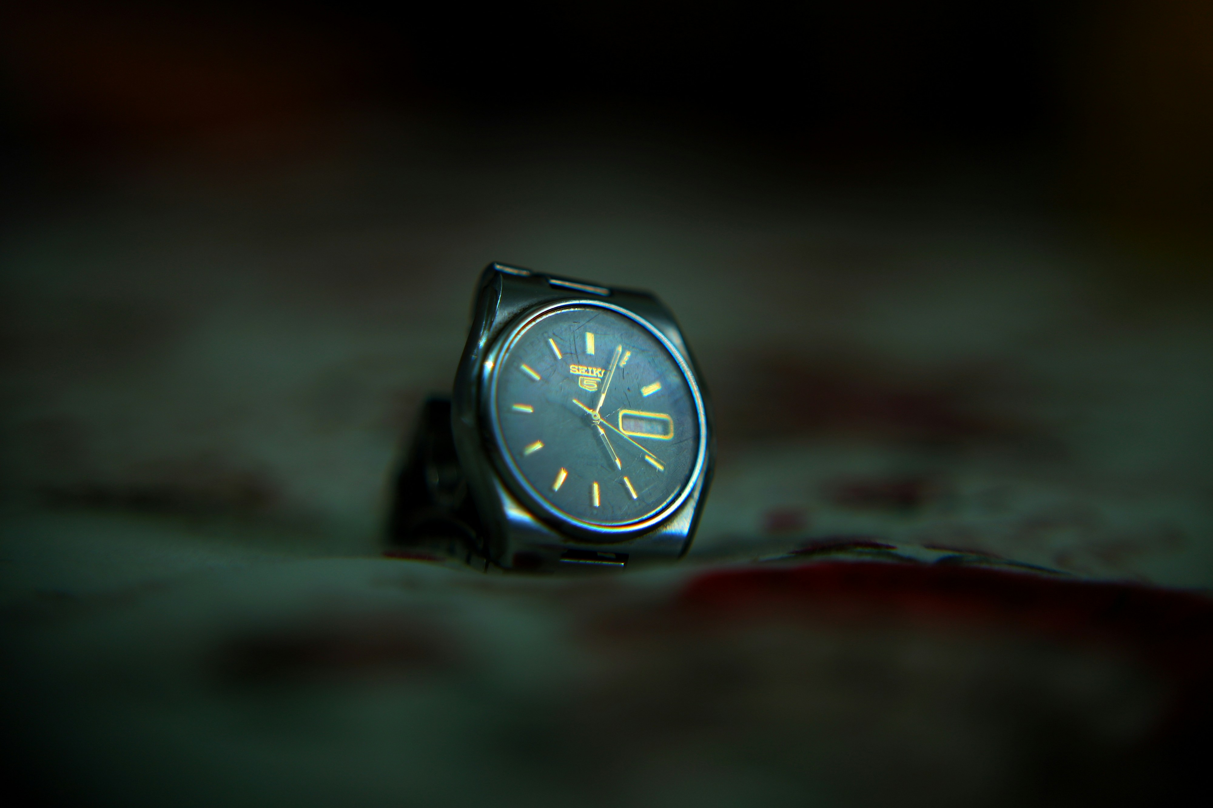 Midnight Dial: A Timepiece Reposes in Emerald-Tinted Shadows