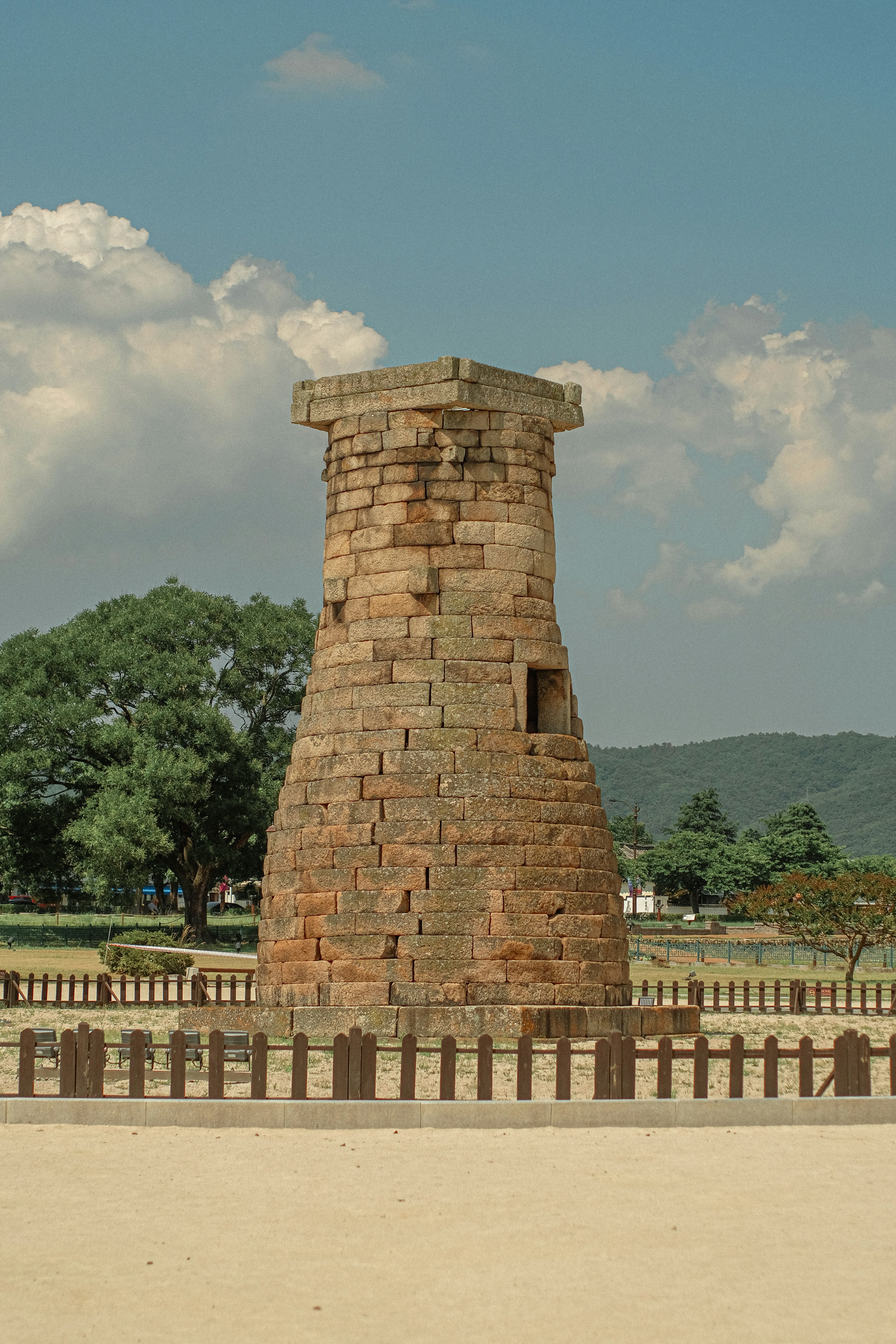 The Park's Stone Beacon: A Weathered Circular Tower Under a Clear Blue Sky
