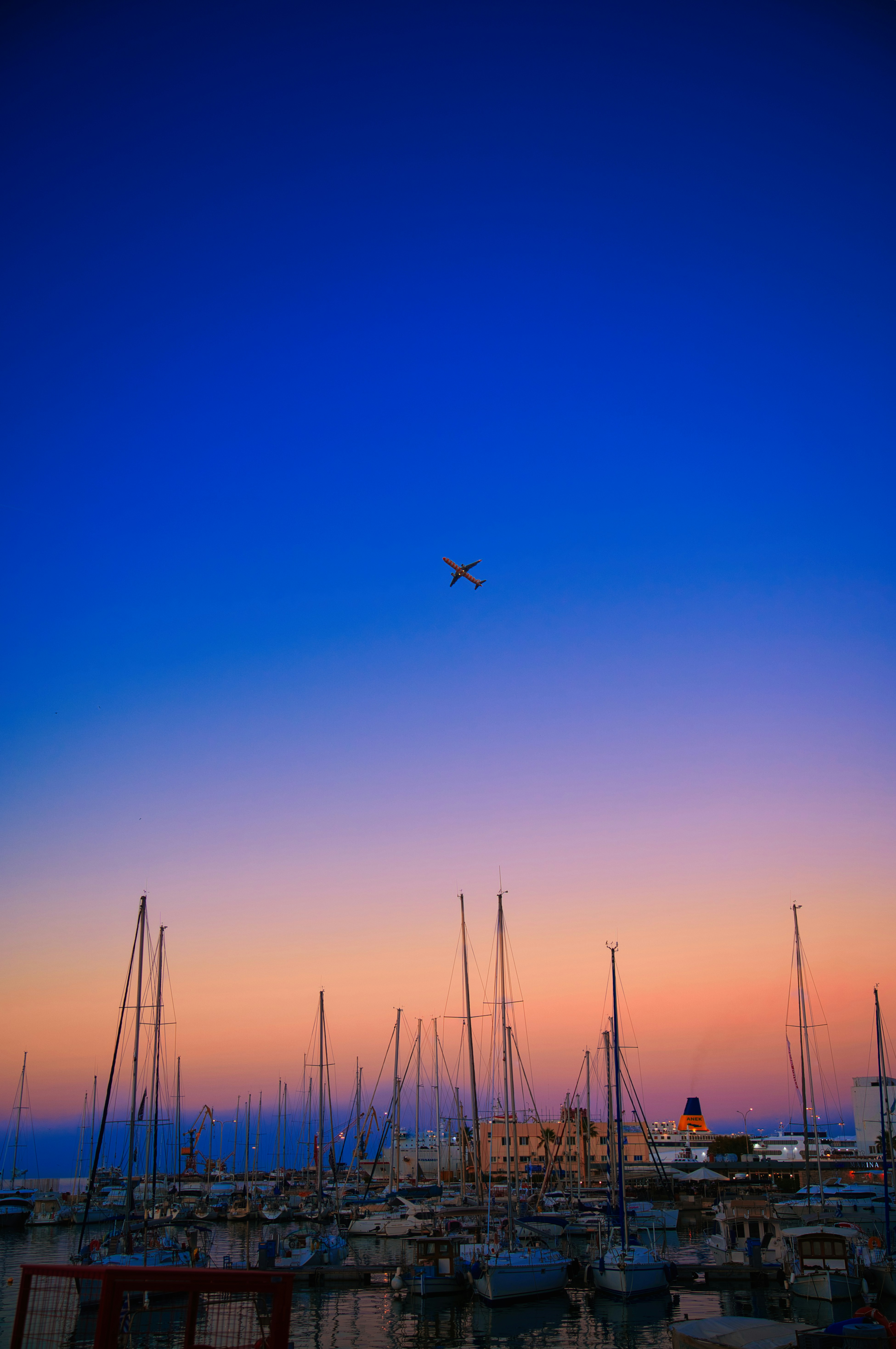 A plane flying over a harbor filled with lots of boats photo – Free ...