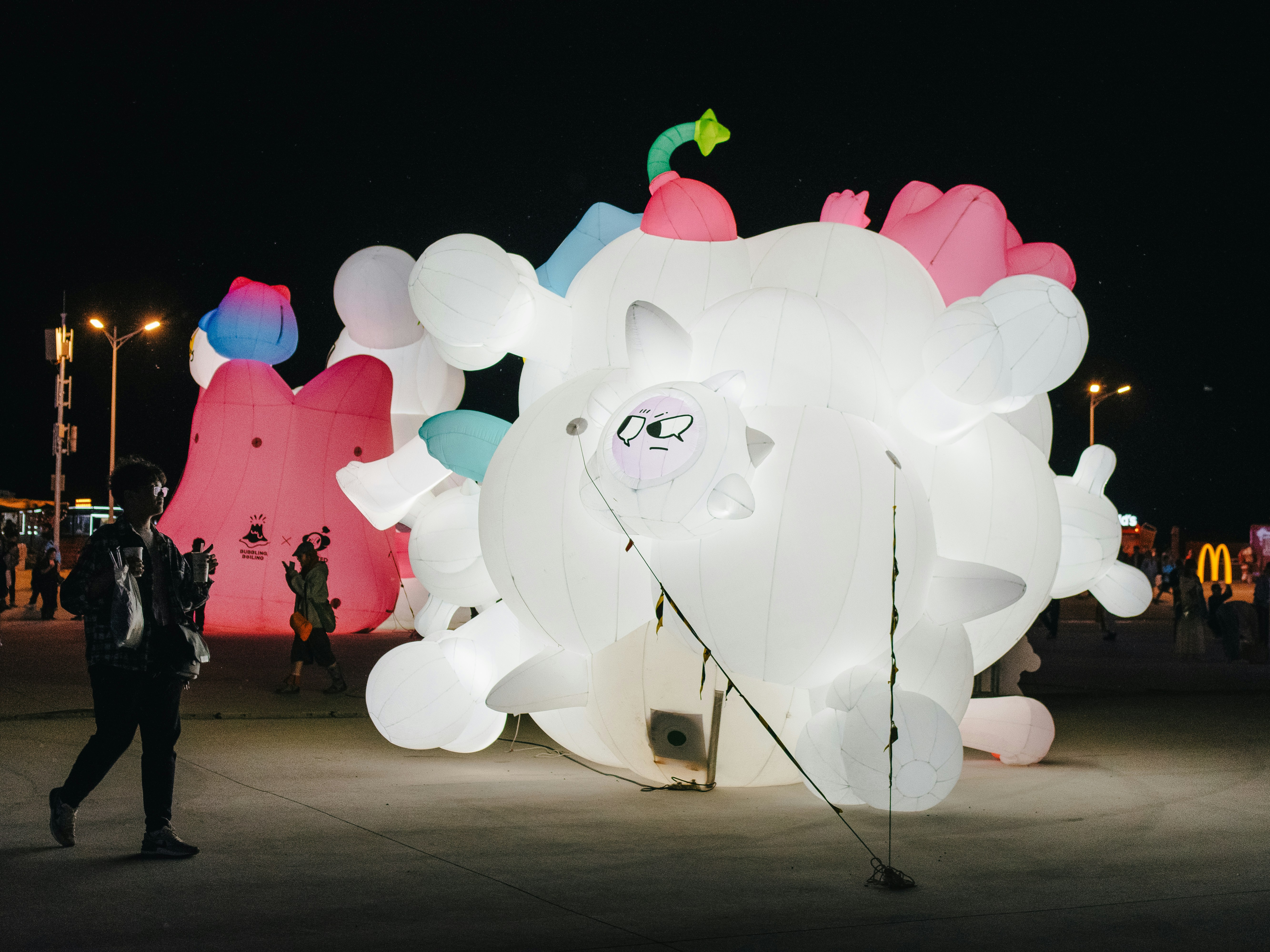 A man walking past a large white sculpture