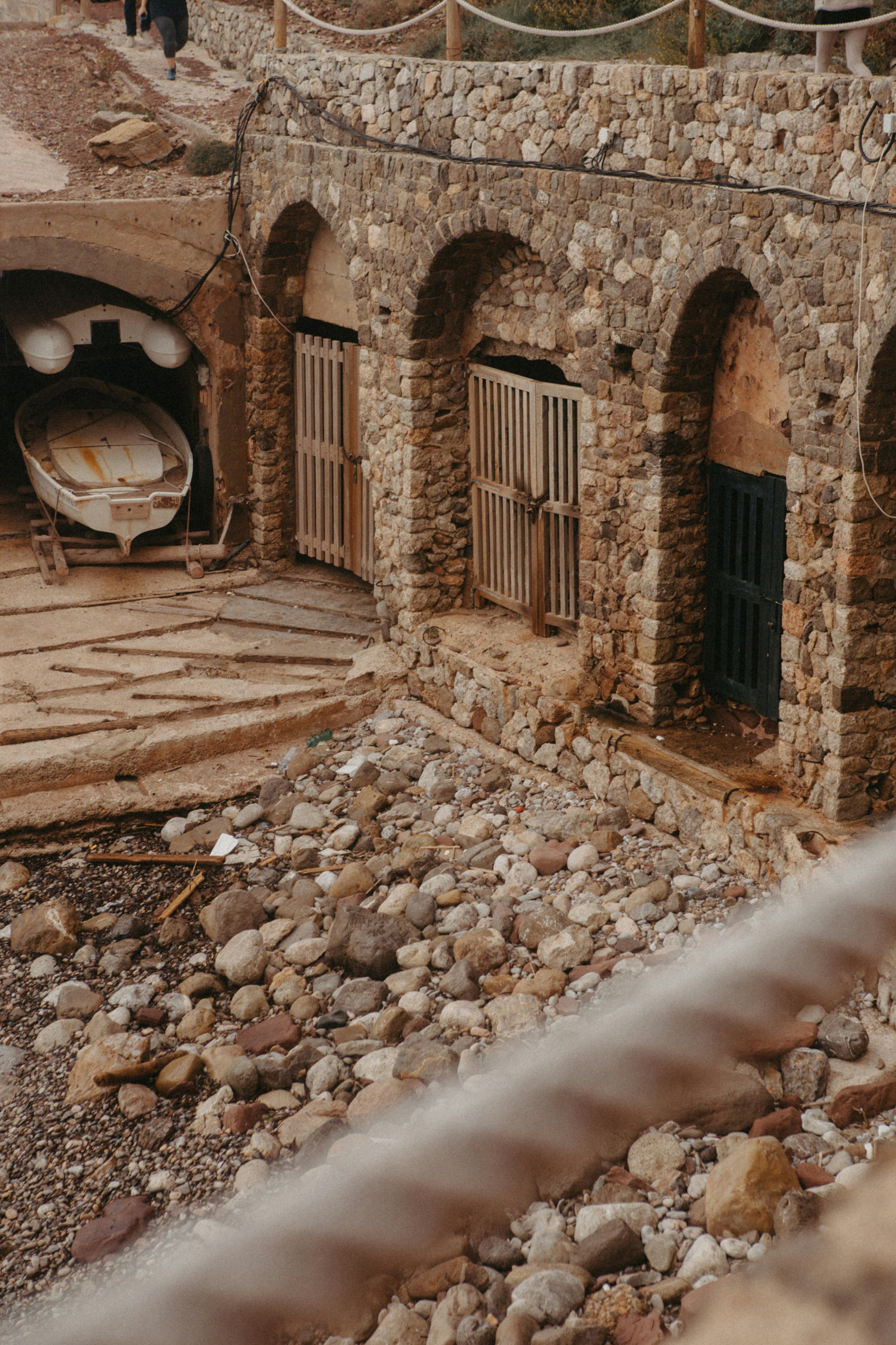 Stone Arches by the Pebbly Shore: A Quiet Harbor Corridor