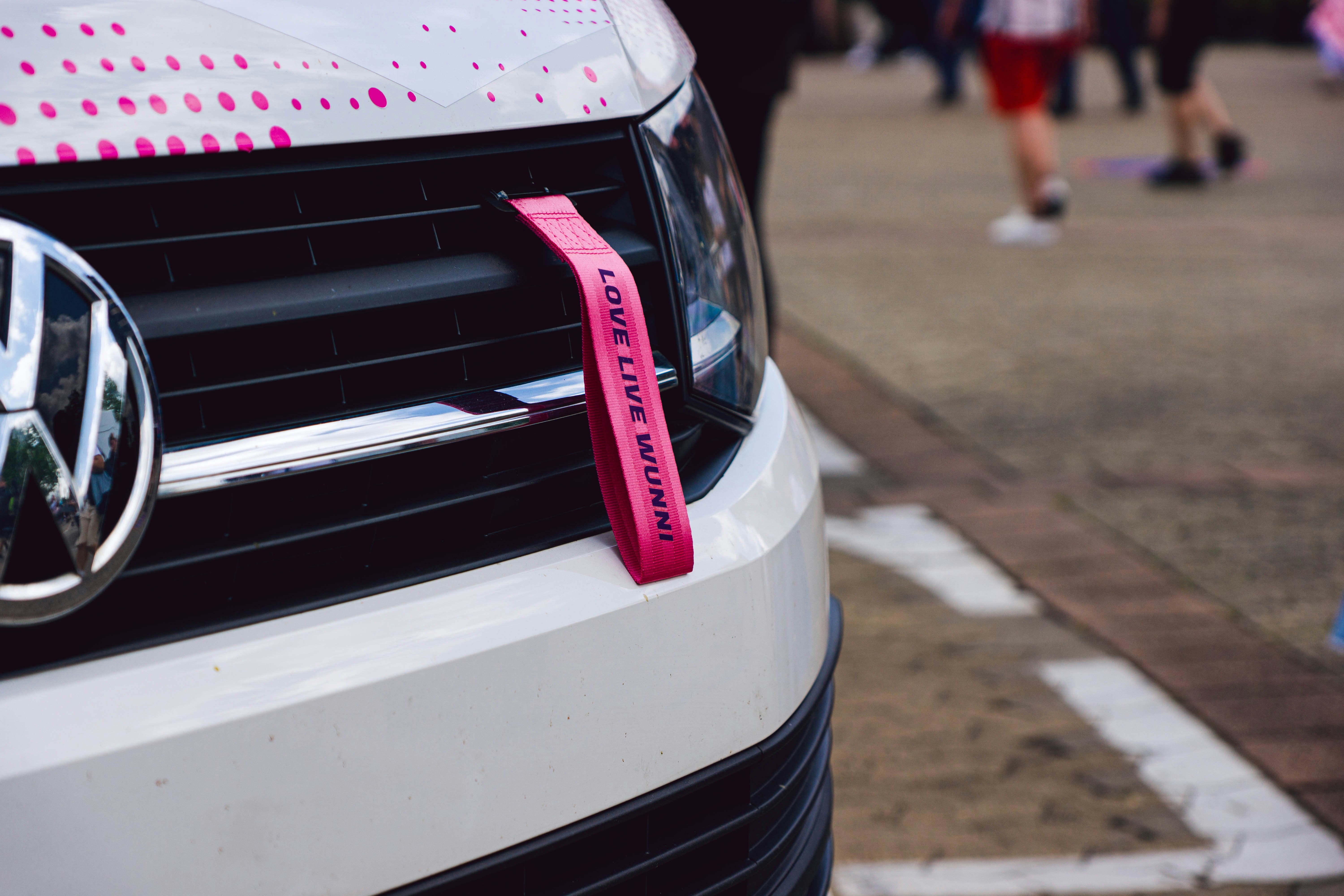 A Pink Tag on VW Grille in a Busy City Moment
