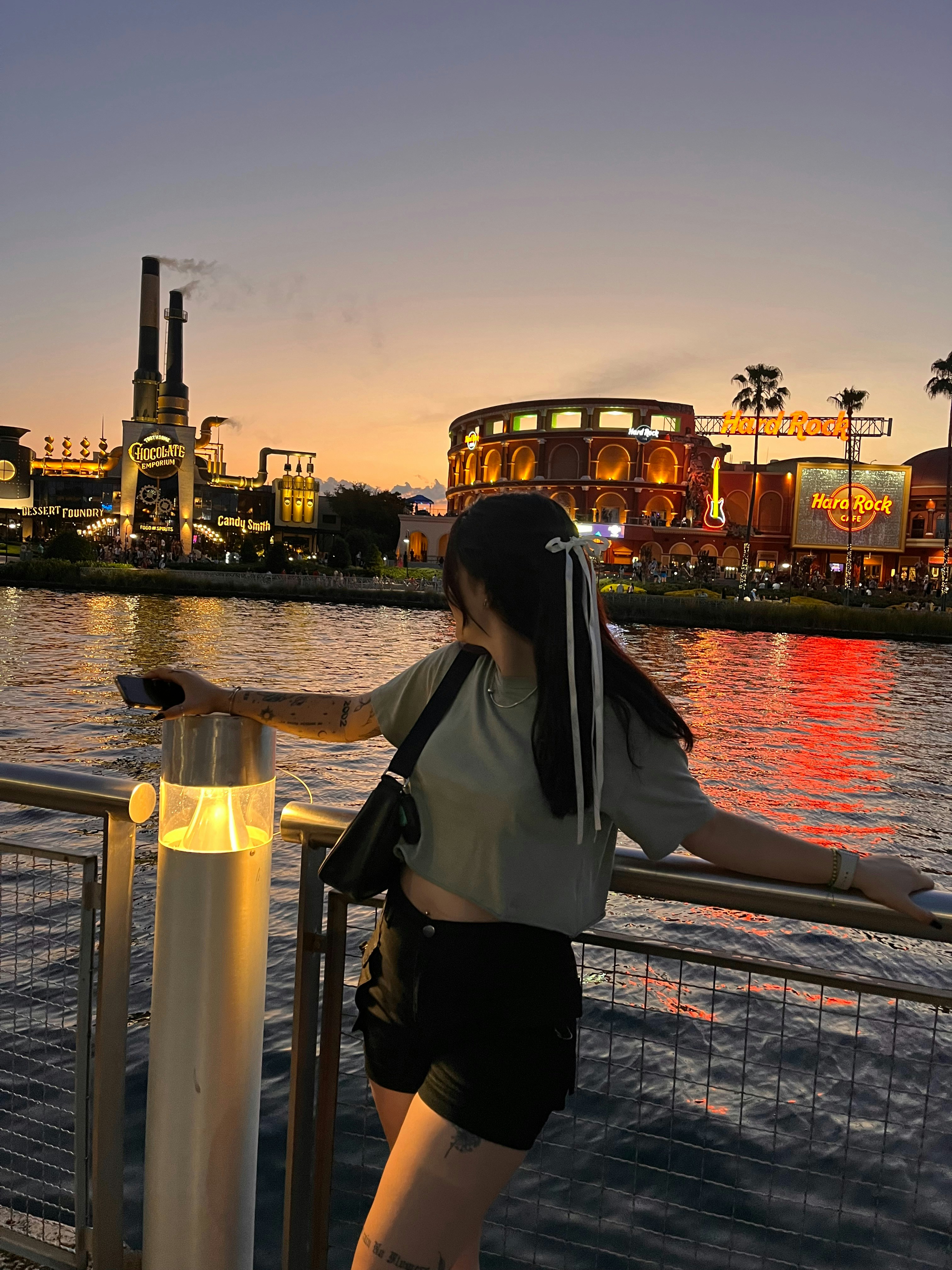Dusk by the Waterfront: A Figure Leaning into Neon Reflections