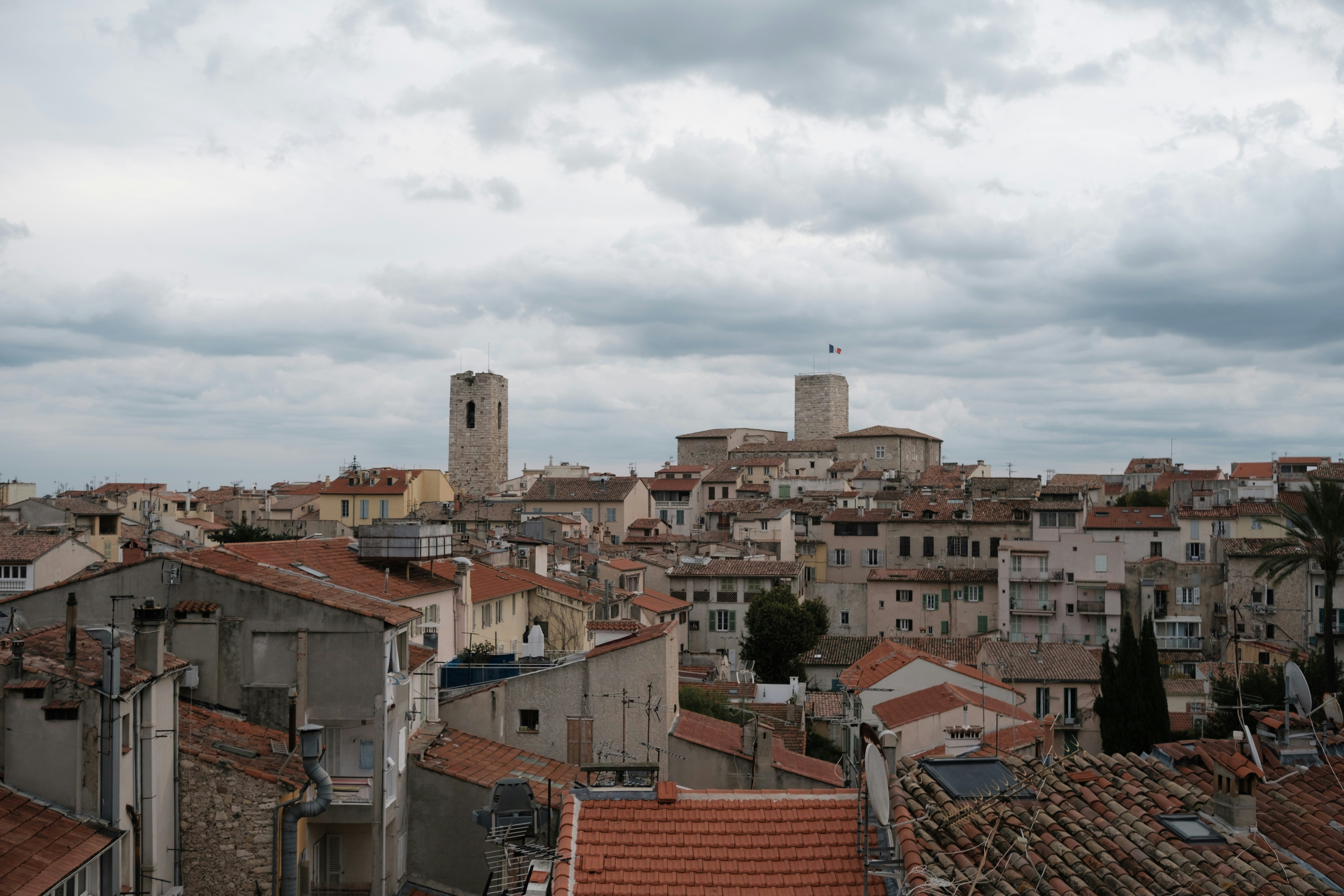 Overcast skies loom over a landscape of rustic rooftops and ancient towers.