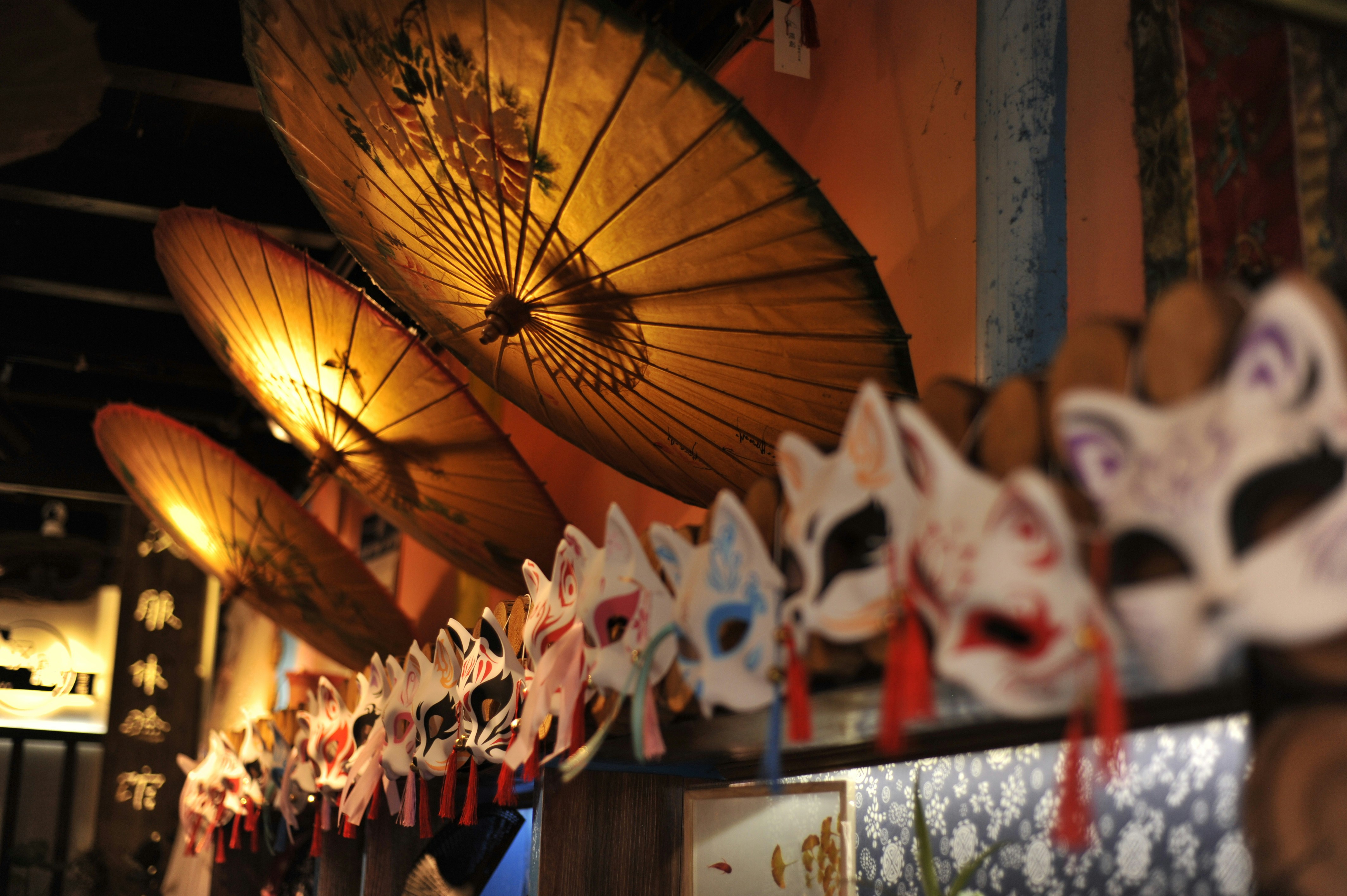 Amber Lanterns Over a Row of Kitsune Masks in a Night Market Corridor