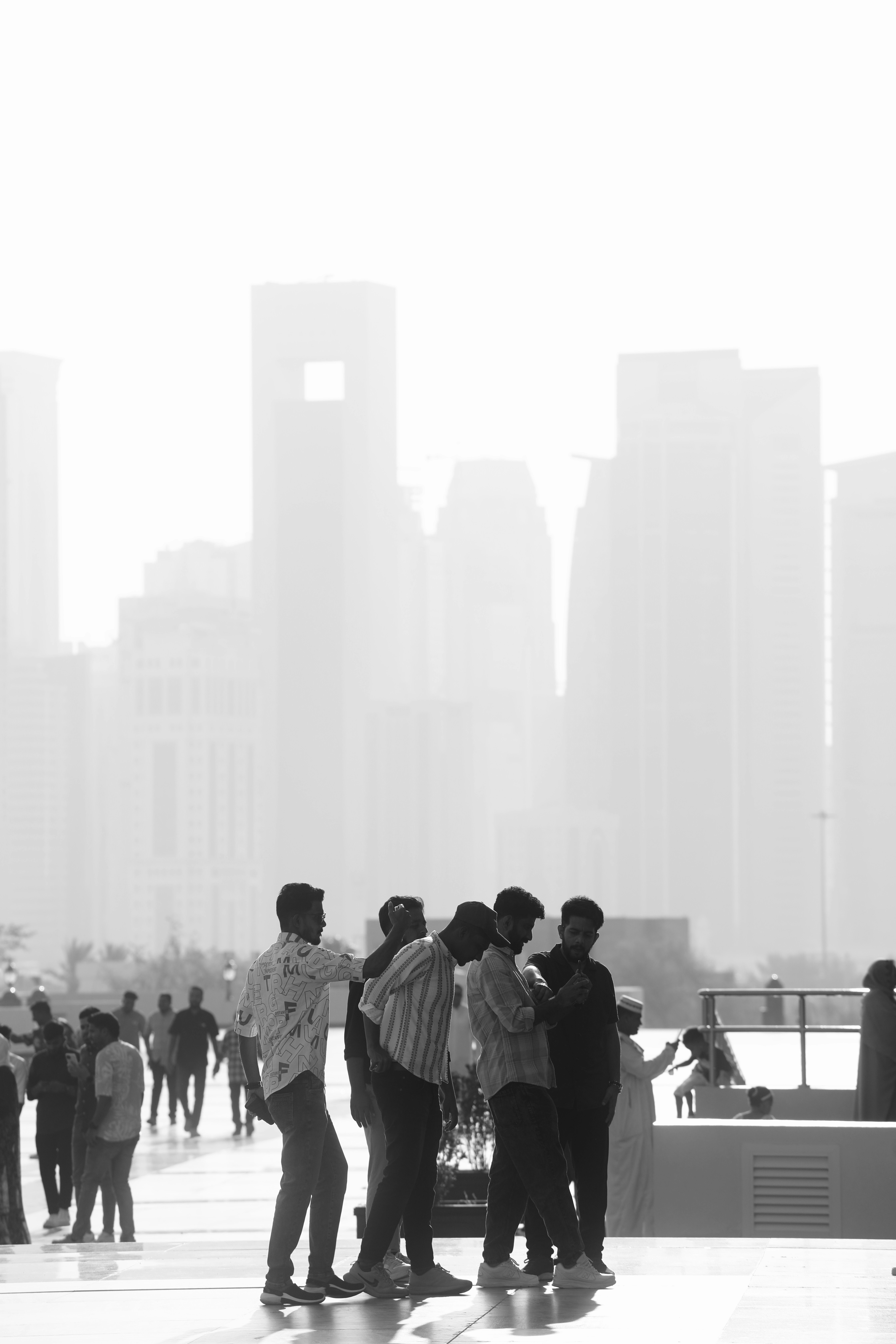 A group of individuals in silhouette against a backdrop of towering city skyscrapers, creating a dynamic urban scene that emphasizes community and interaction.