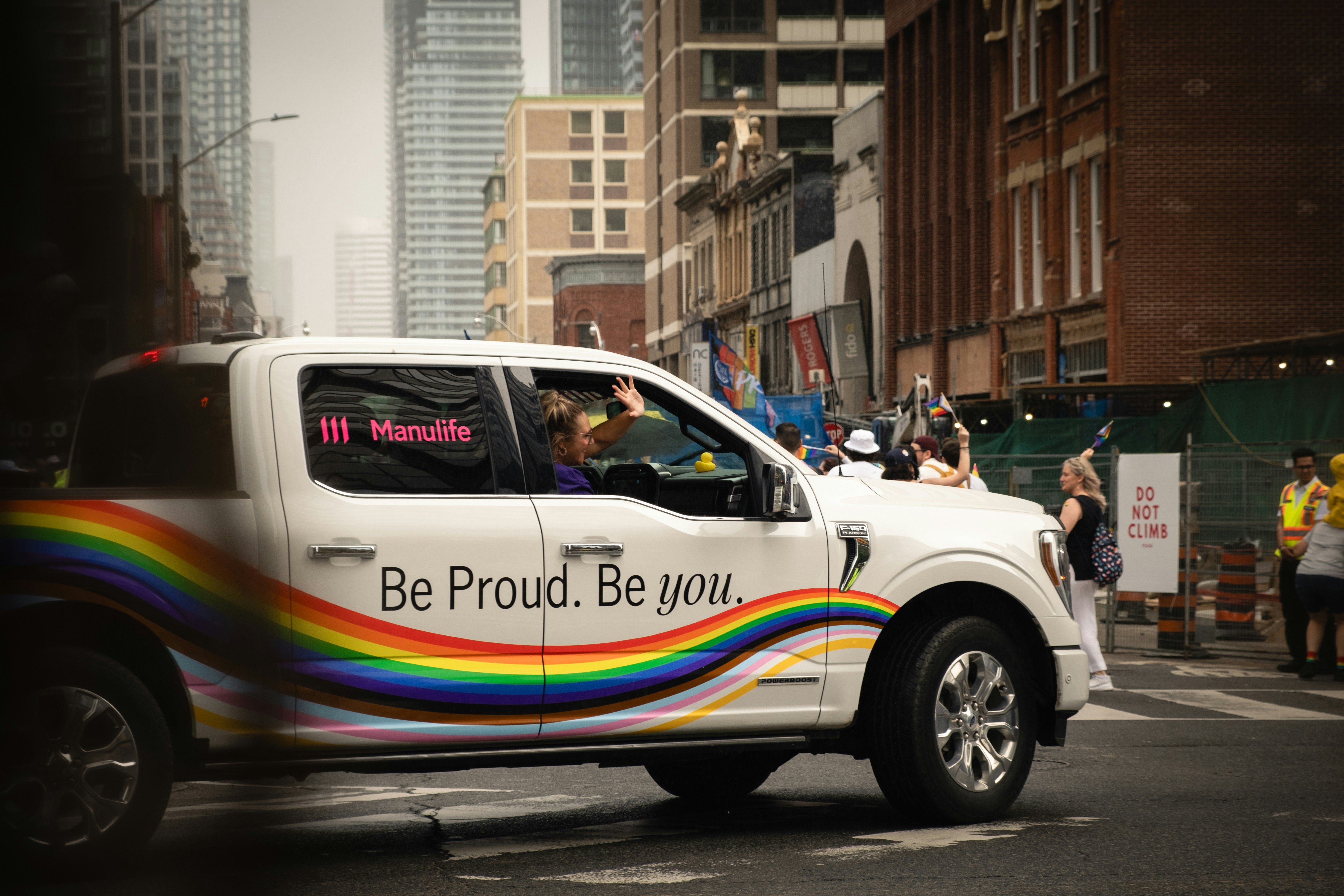 Be Proud. Be You.: Rainbow Pride Van Rolling Through a City Street