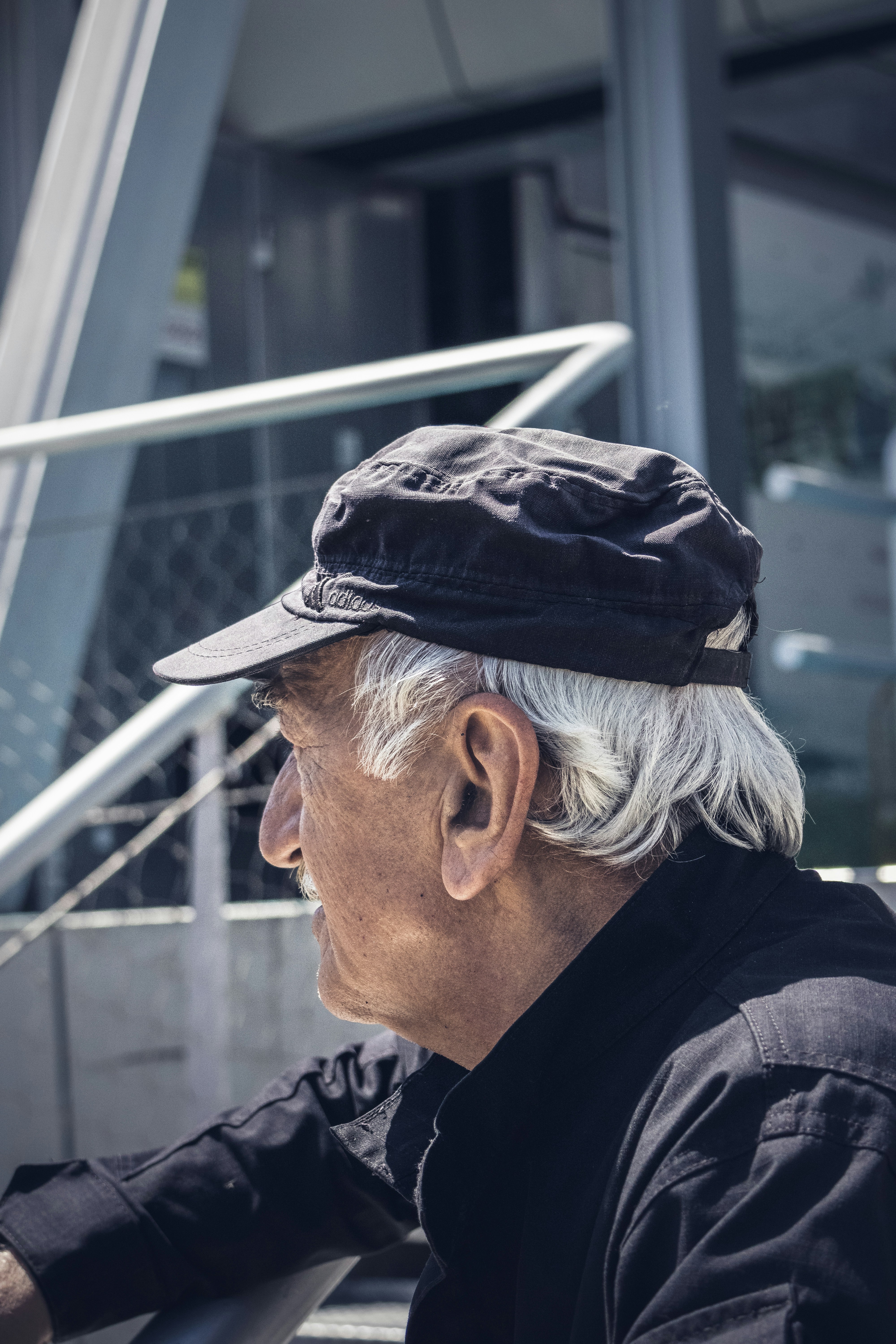 Side Profile in Concrete Light: An Elder's Quiet City Moment