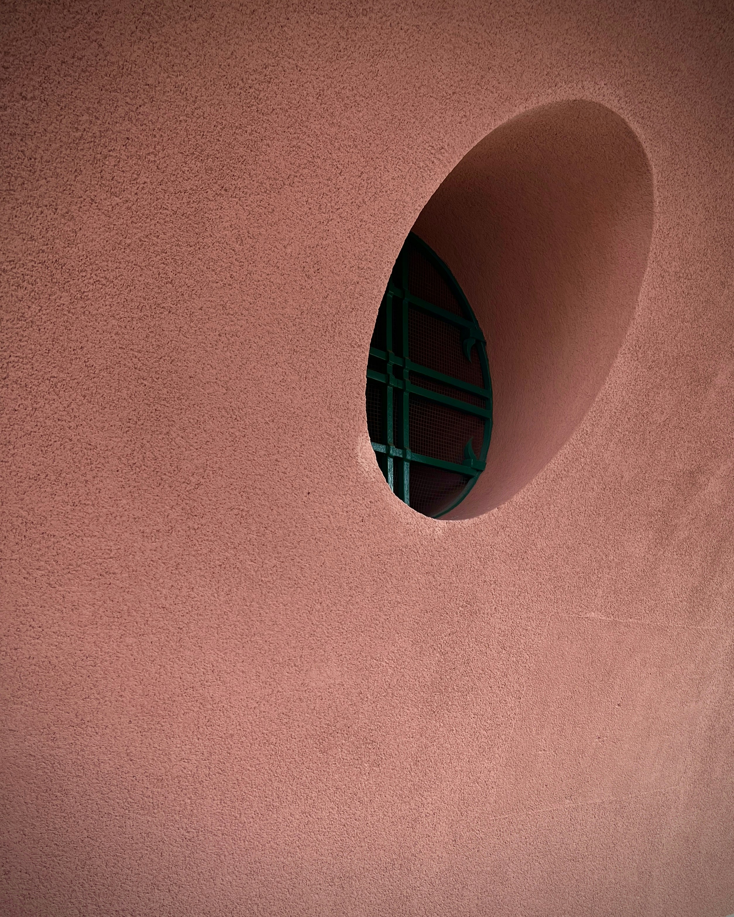 Peach-Circle Portal: A Circular Vent Peeking Through Textured Wall