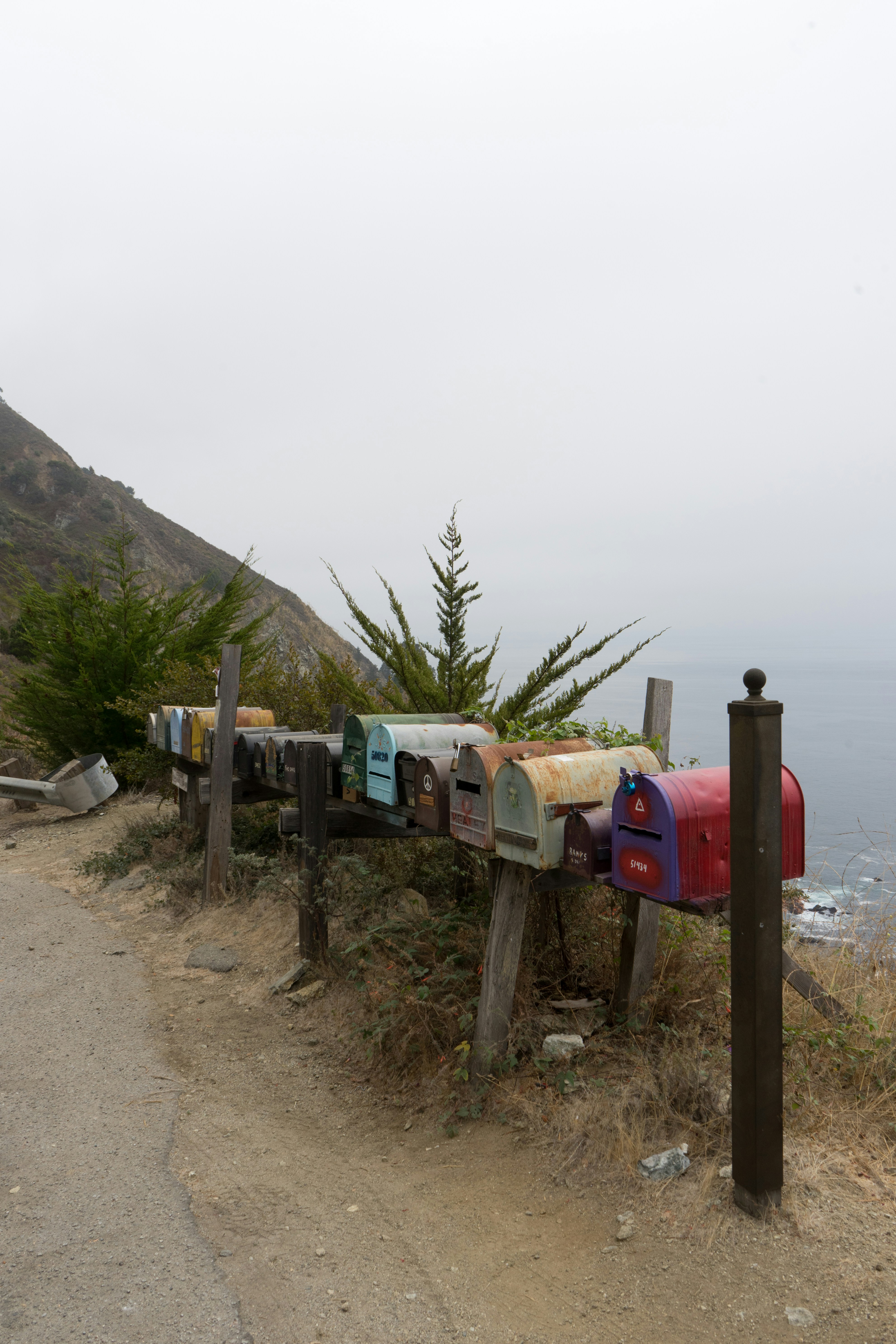 Palette Along the Cliff: A Row of Colorful Mailboxes by the Coastal Path