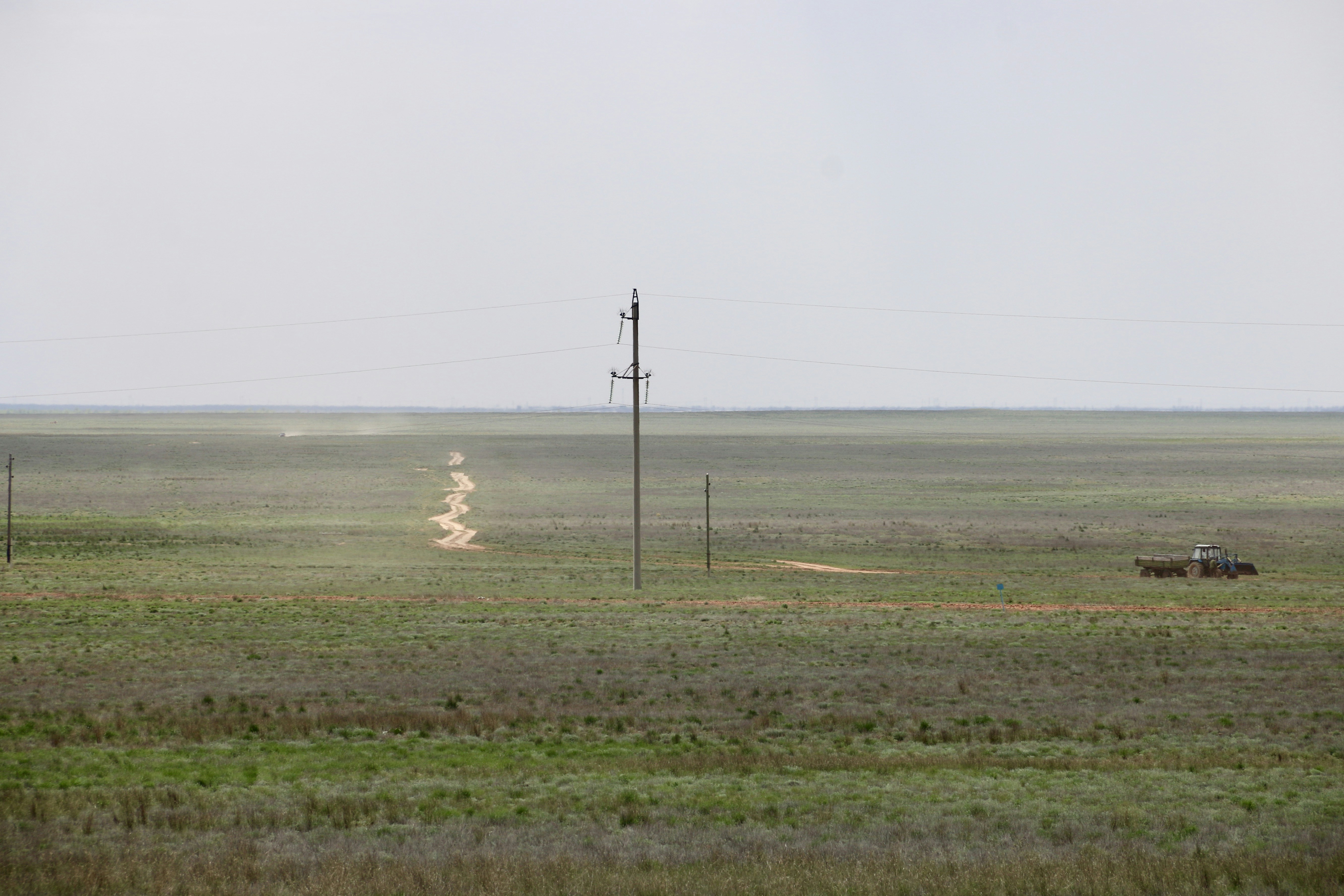 Lone Power Pole Guiding a Winding Prairie Road to the Horizon