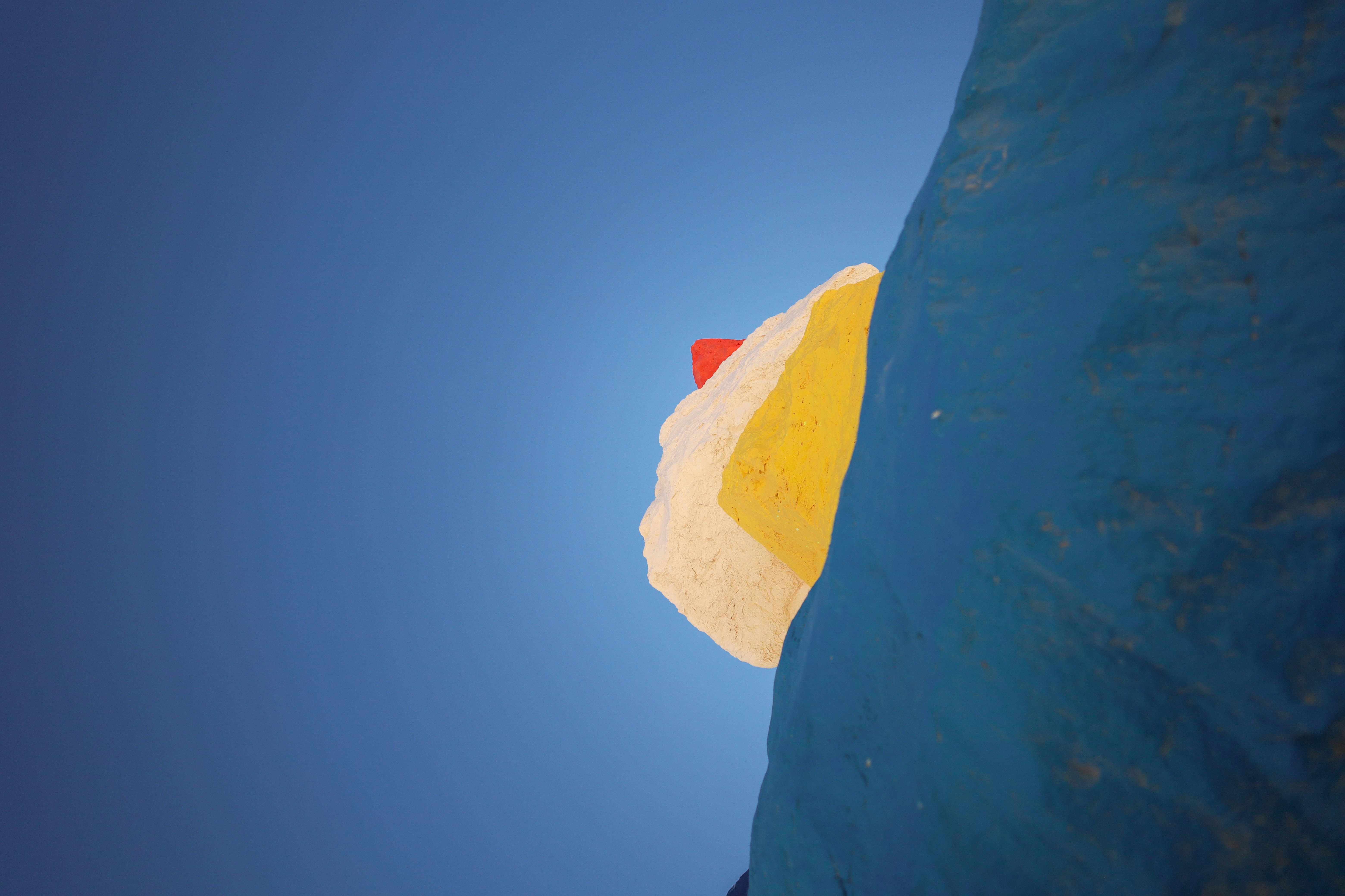 Ice Prism on a Polar Slope: a colored facet set in blue ice against a clear sky