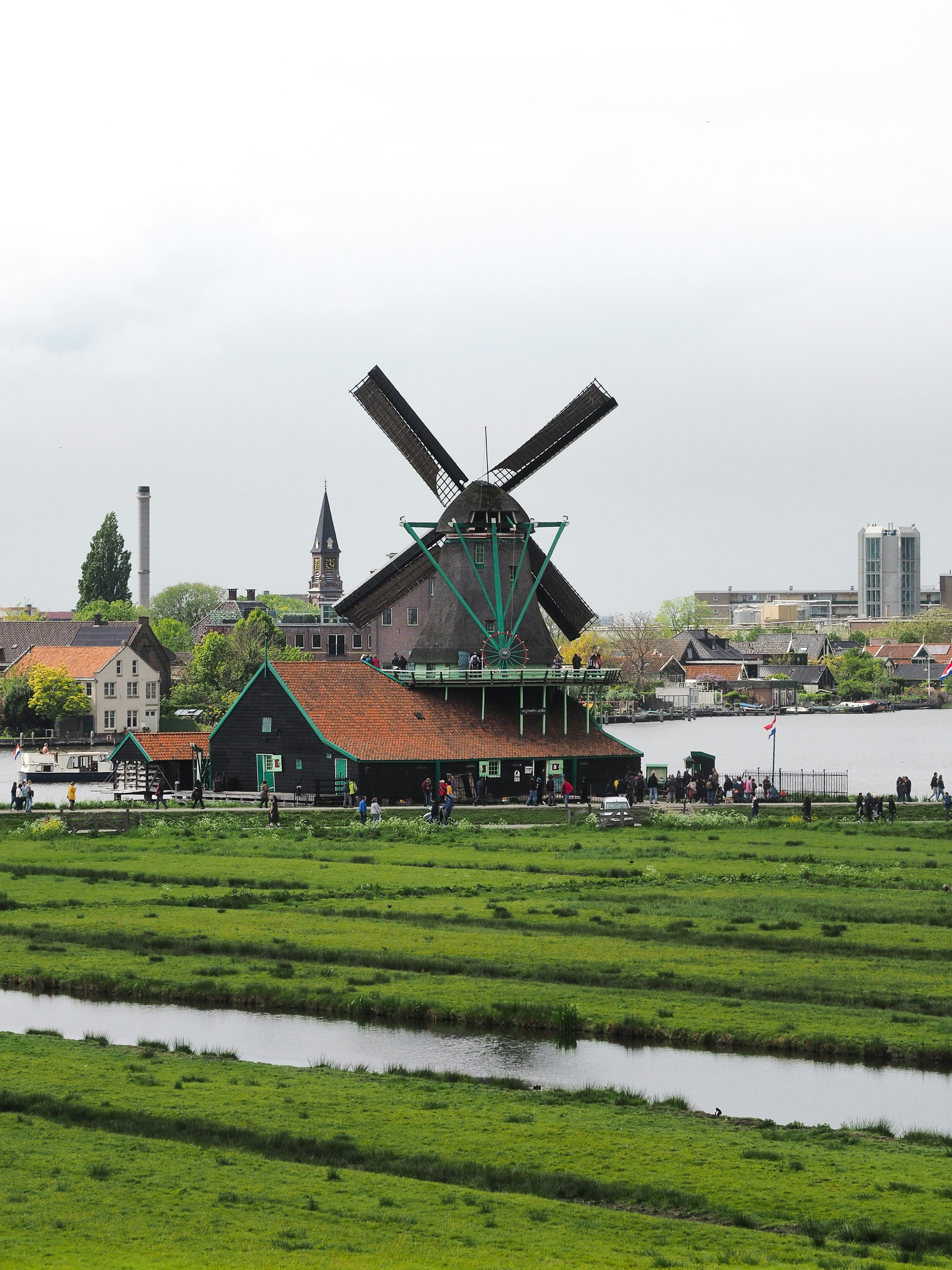 Green Windmill Overlooking a Quiet Dutch Riverbank