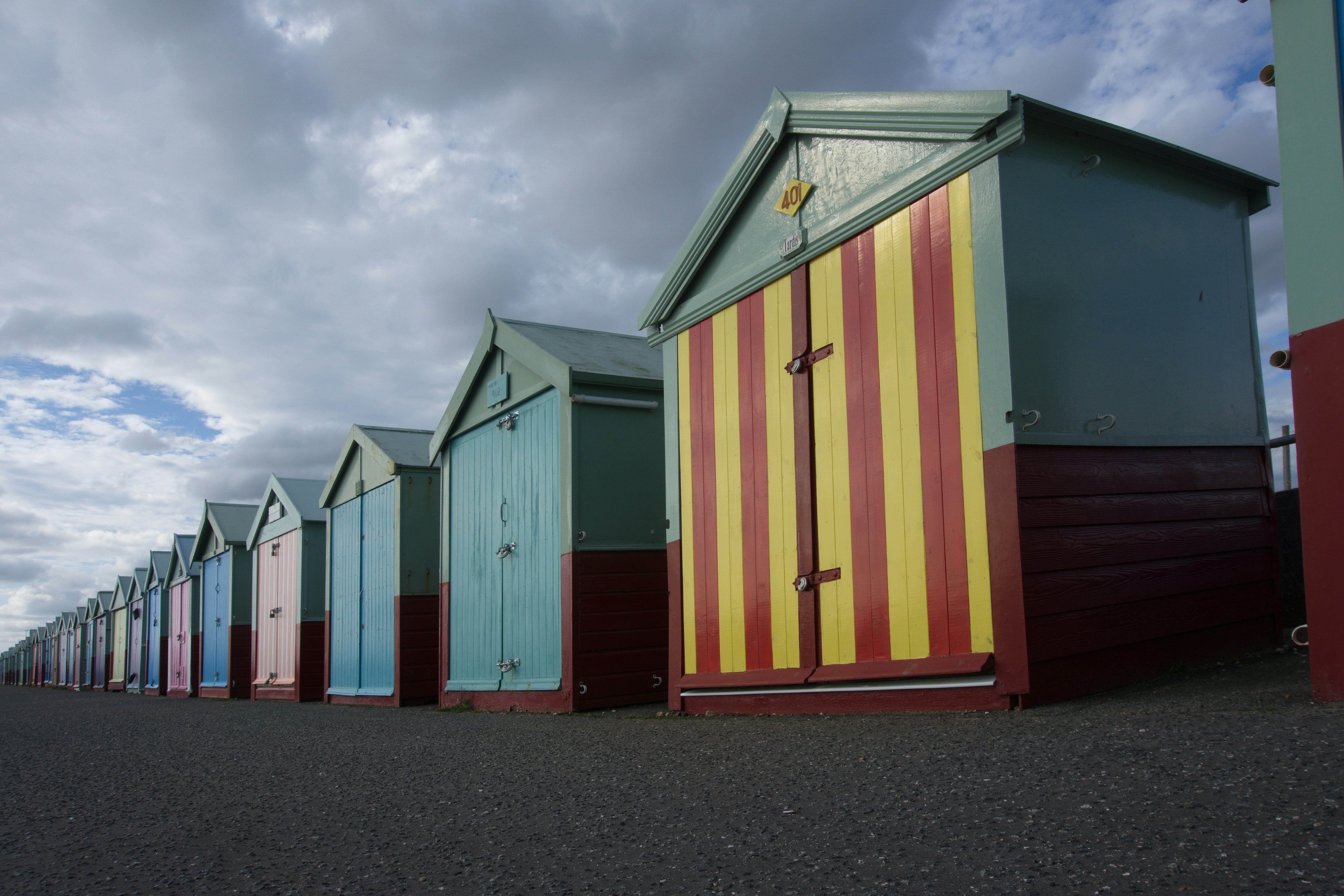 A row of colorful beach huts sitting next to each other photo – Free ...