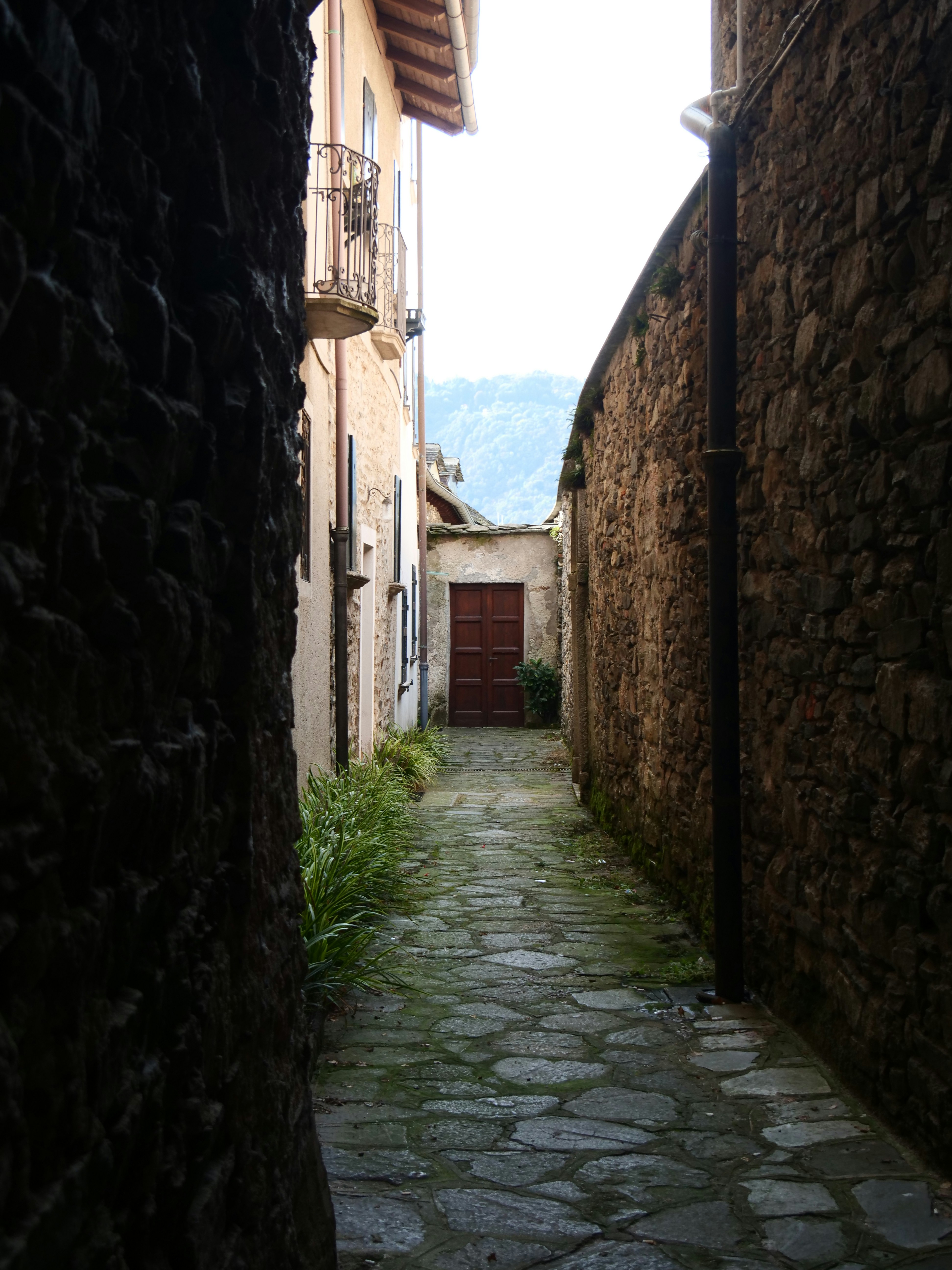 A narrow alley way with a stone walkway between two buildings photo ...