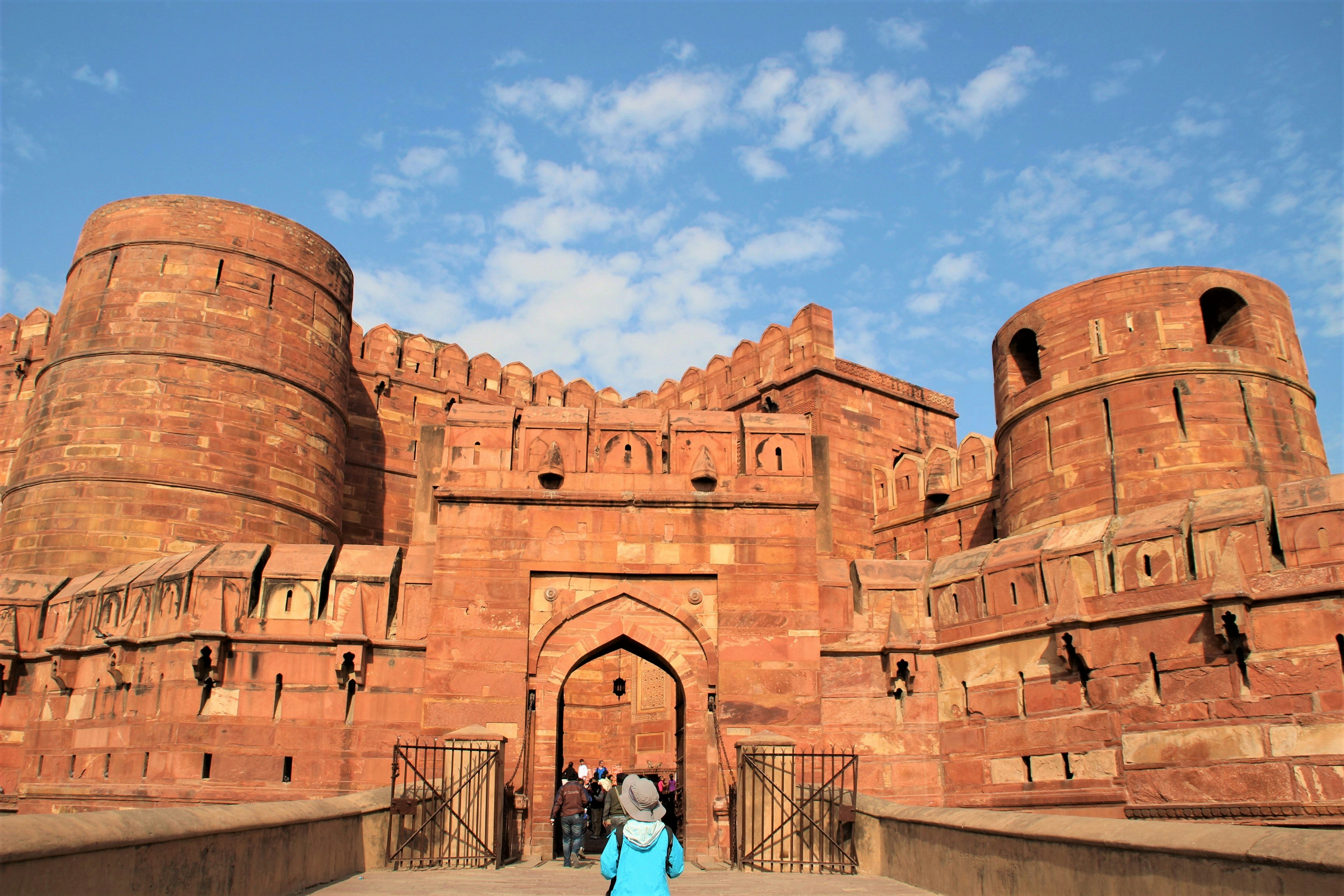 Gateway to the Red Fort: A Traveler Before the Arched Entrance