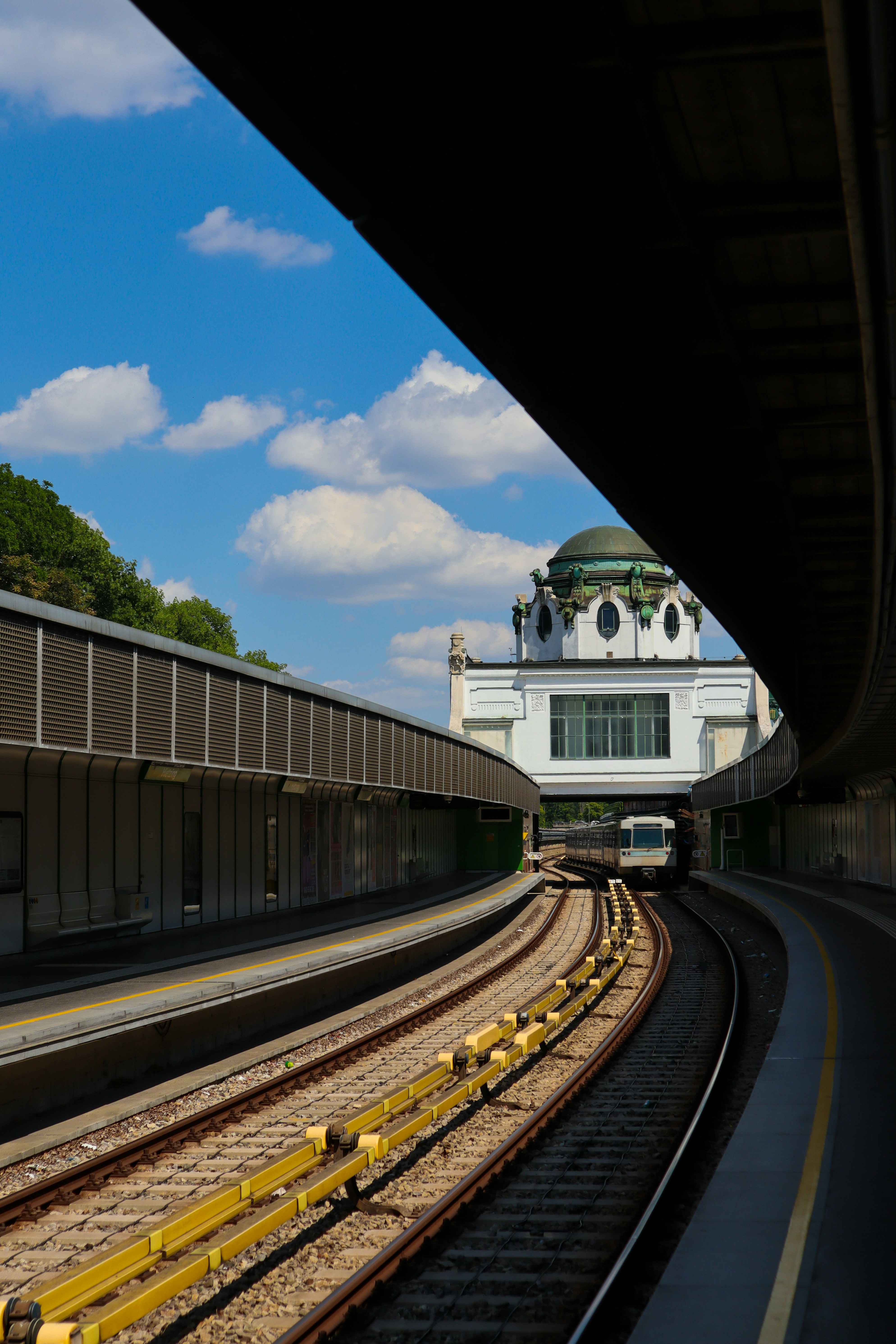 A train traveling down train tracks next to a train station photo ...