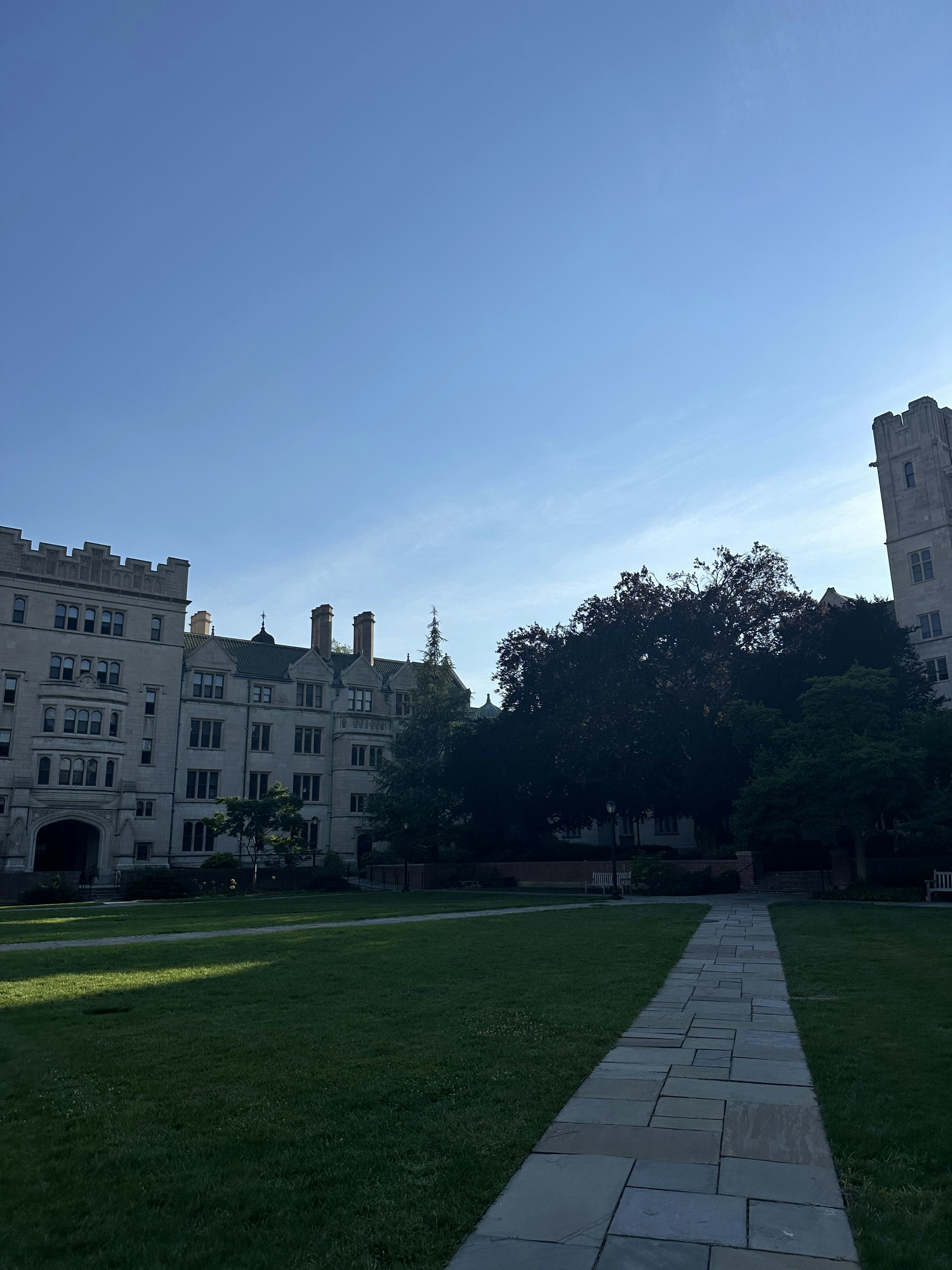 Azure Sky over Stone Campus: Pathway to the Historic Quad